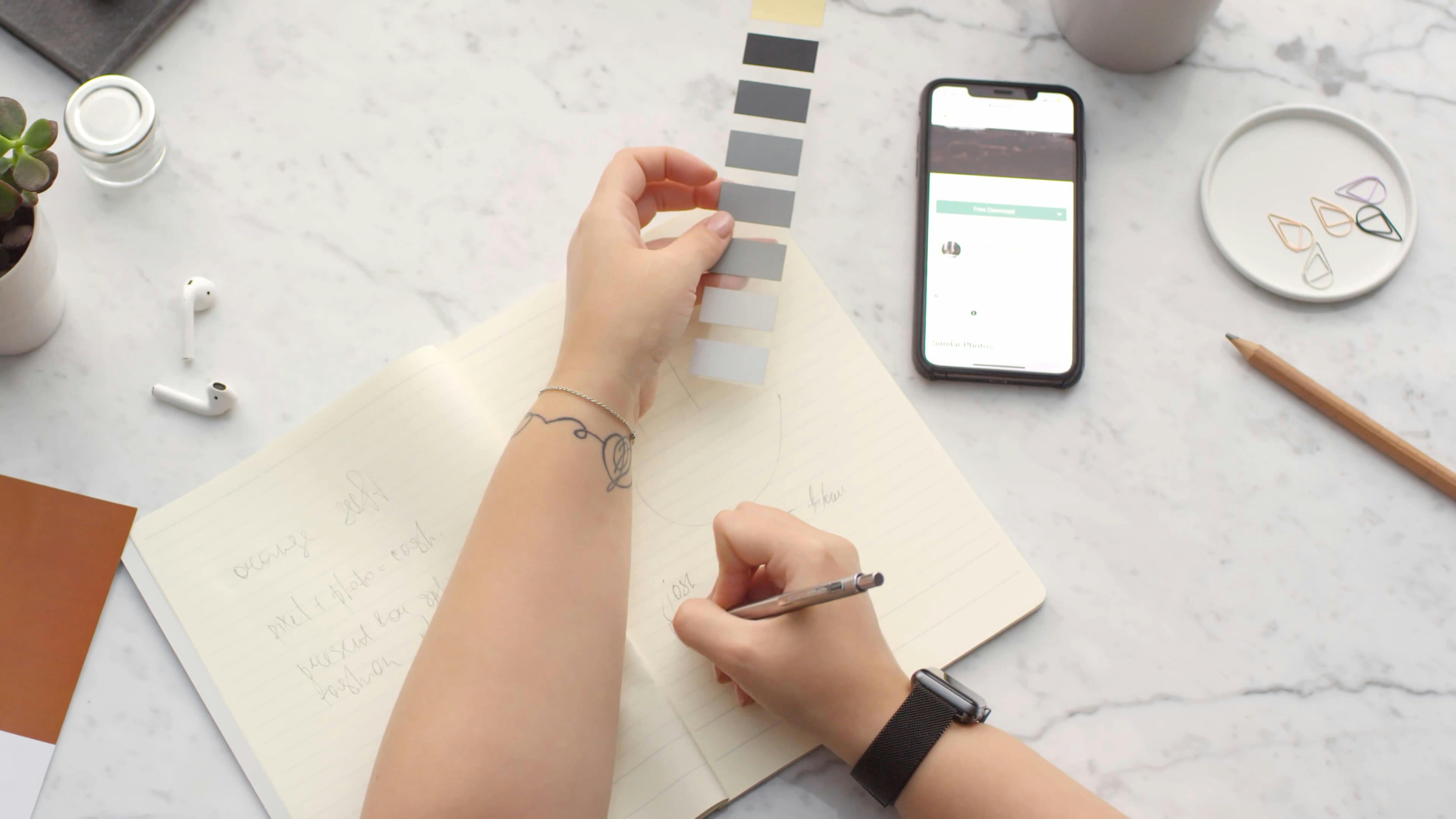 A Woman Taking Notes On Gray Shaded Photos Stored In A Cellphone · Free ...