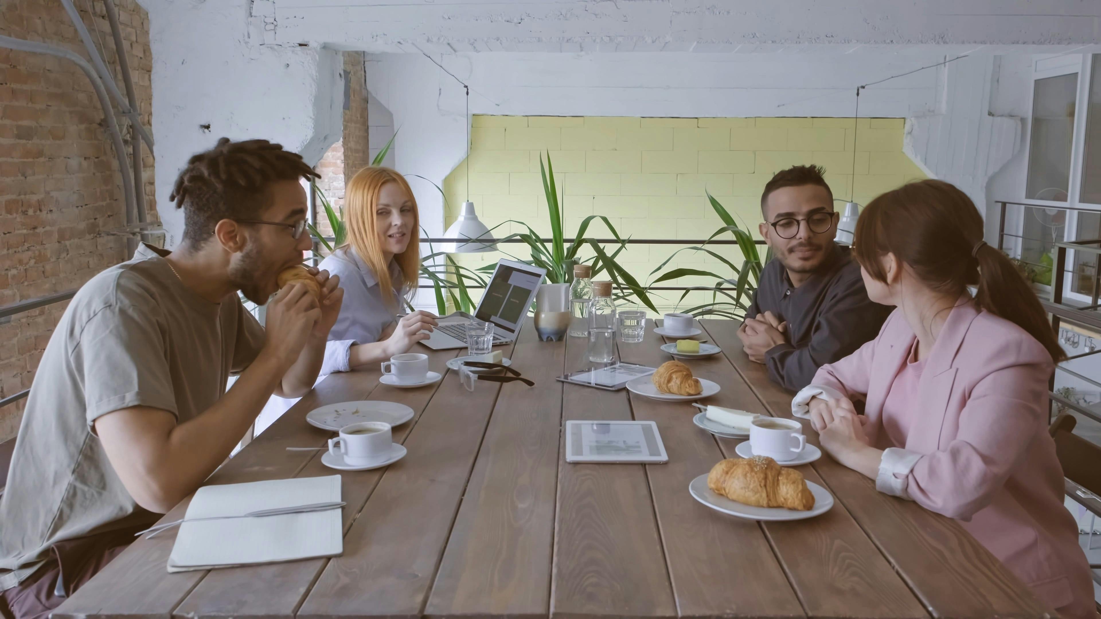 A Group Of People Eating While Working In The Workplace Free Stock ...