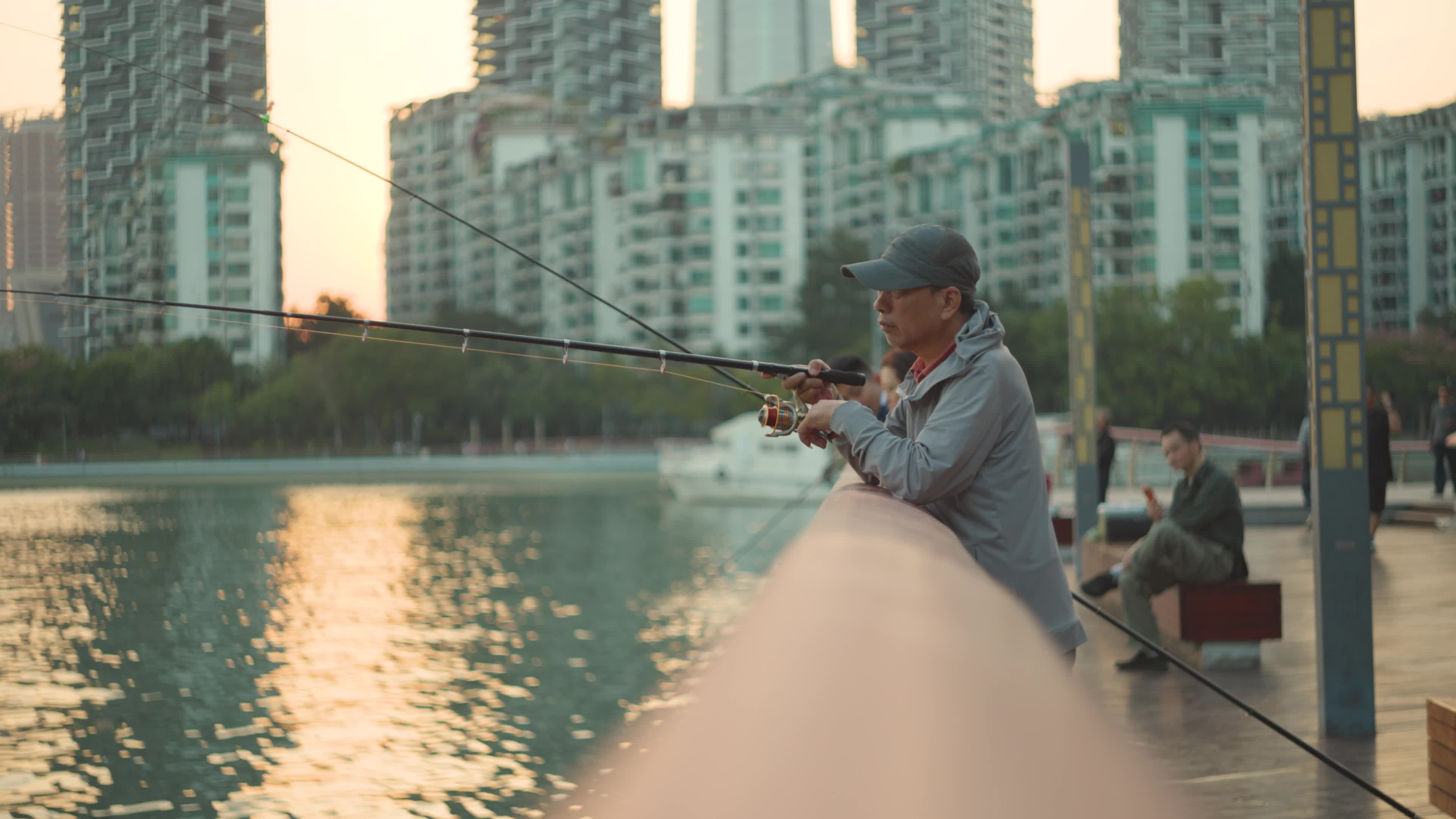 Man Fishing on an Urban Waterfront at Sunset Free Stock Video Footage ...