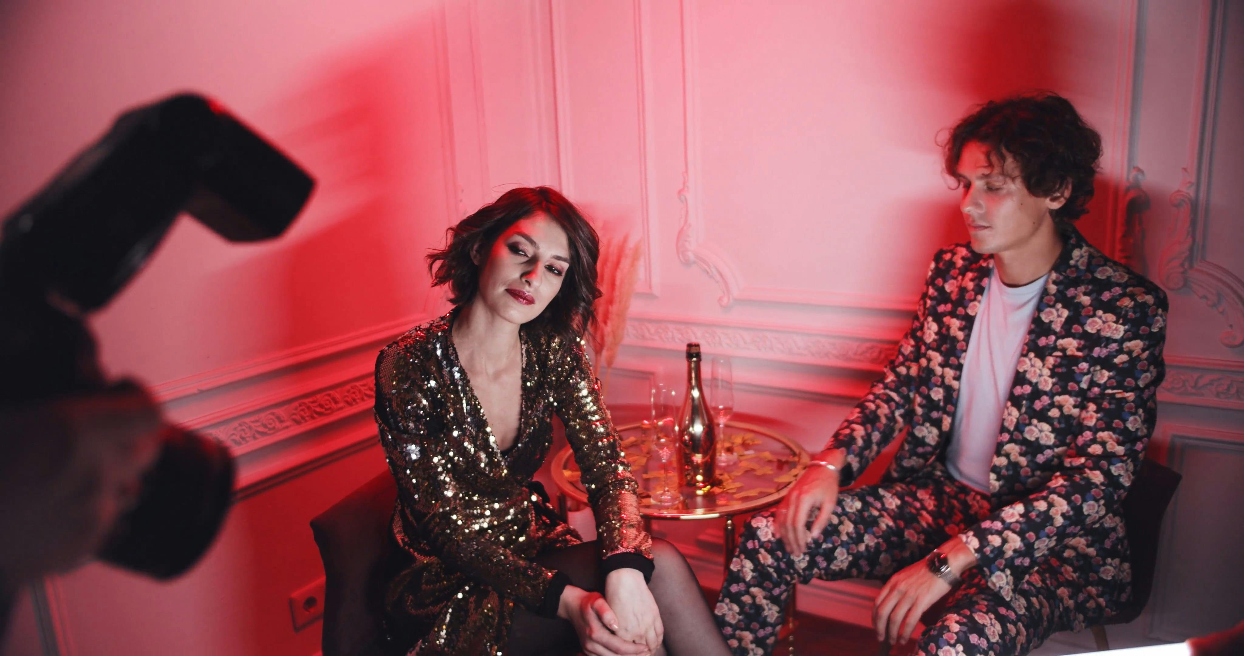 A Woman In A Gold Dress Having A Sip Of Alcoholic Drink While Posing In ...