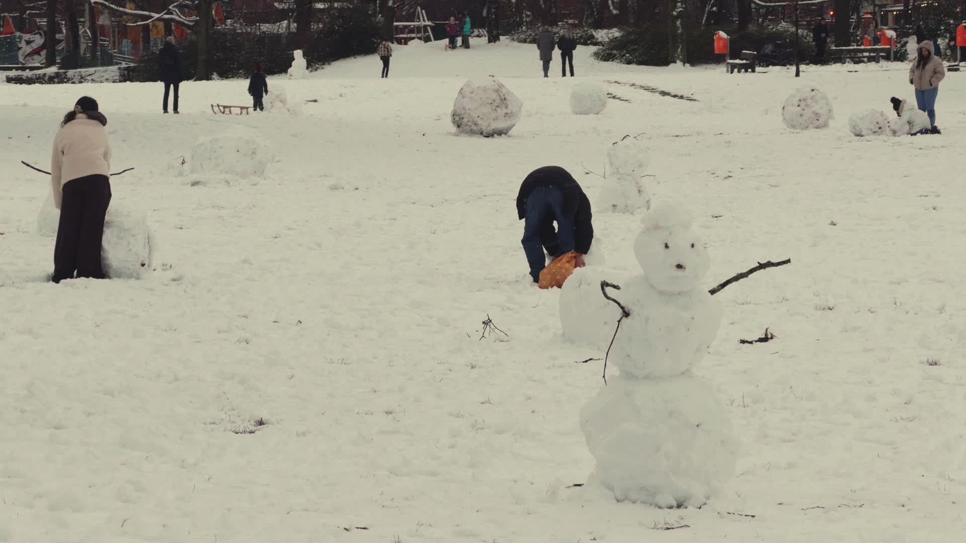People Enjoy Snowy Day Building Snowmen Outdoors Free Stock Video ...