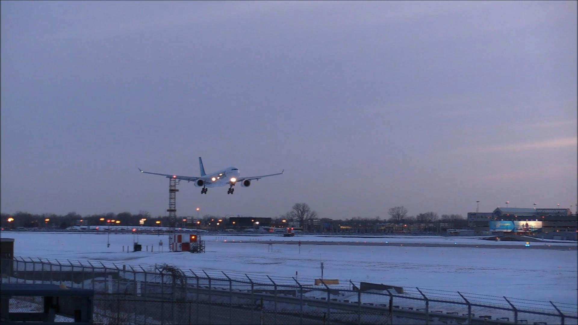 An Airplane Landing At An Airport During Winter Over Snow Covered Field ...