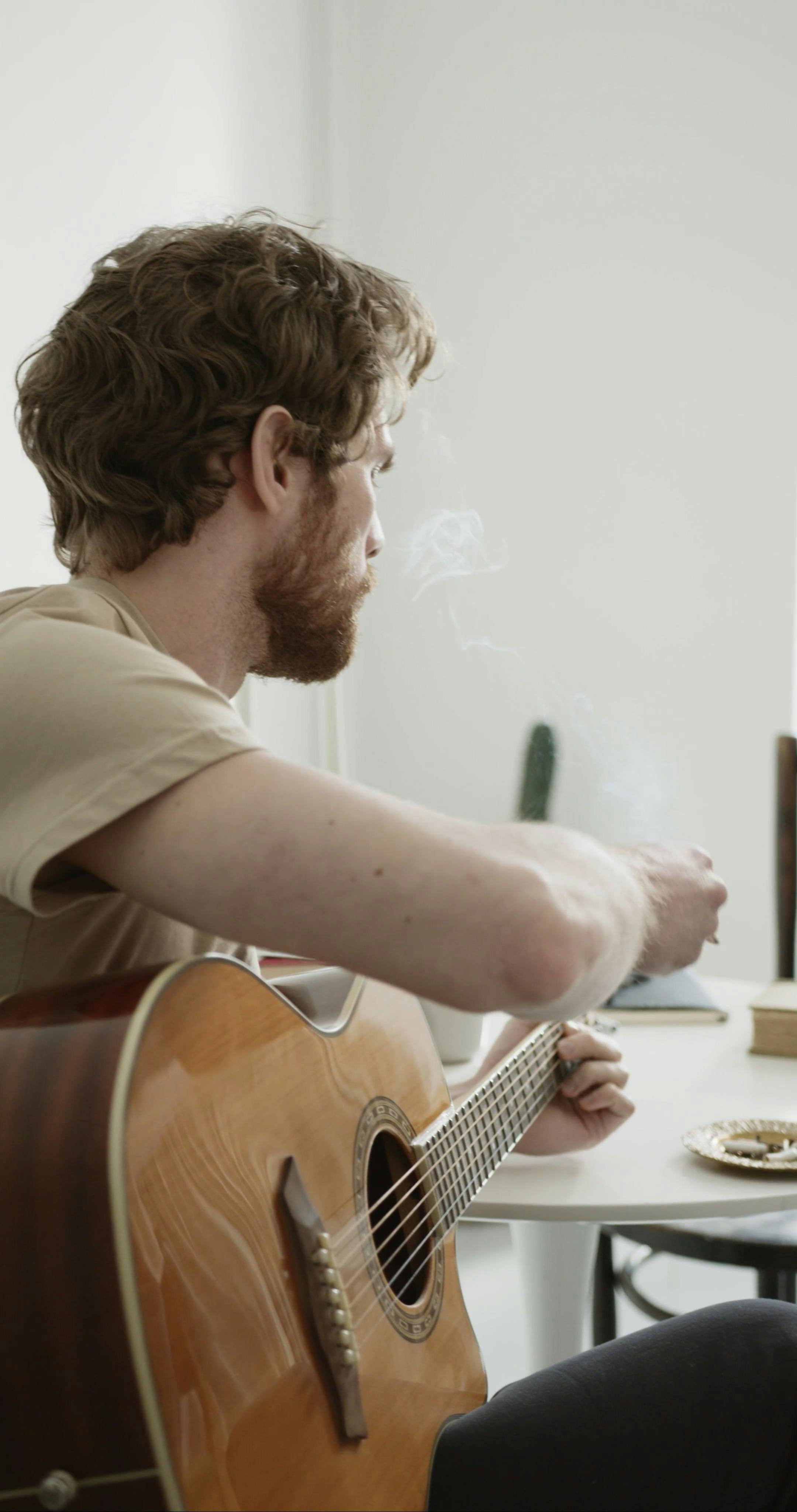 Man Smoking while Playing Guitar · Free Stock Video