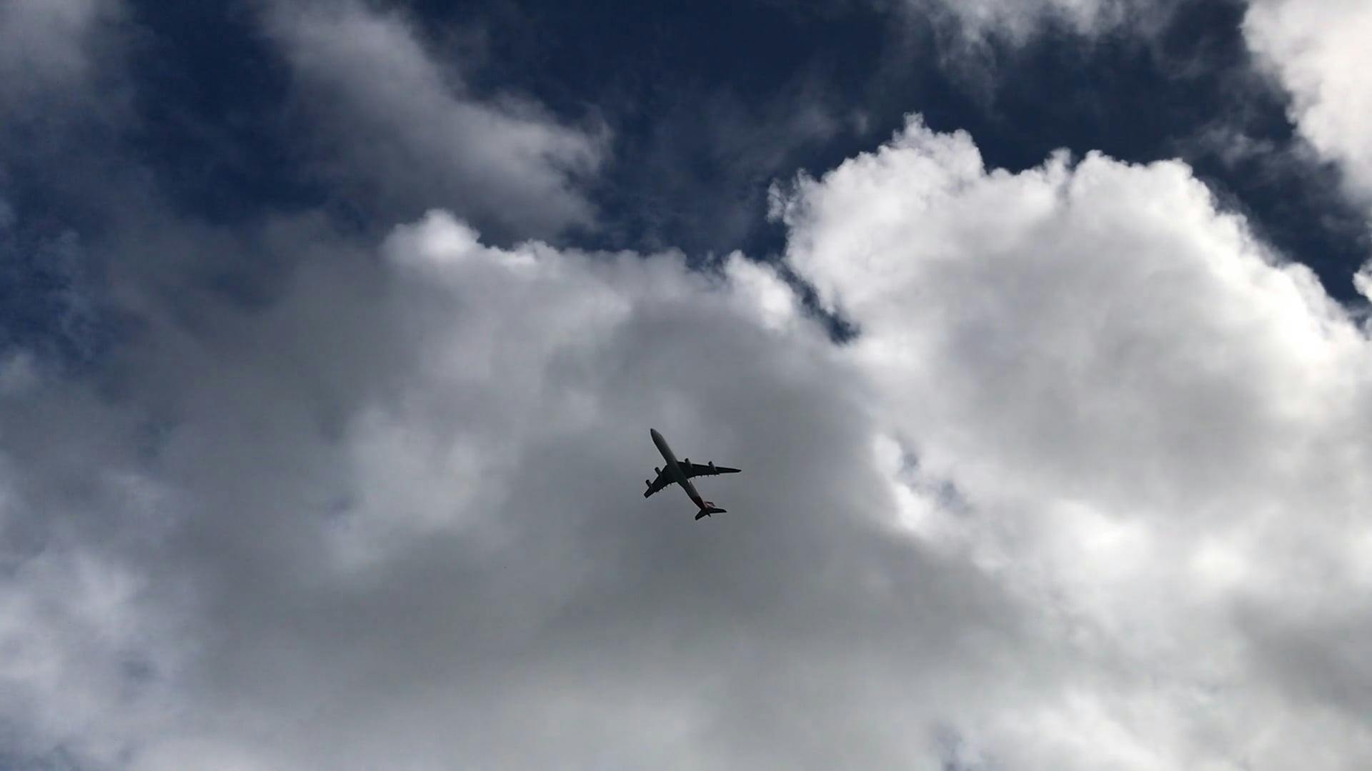Airplane Flying Under A Blue And Cloudy Sky · Free Stock Video