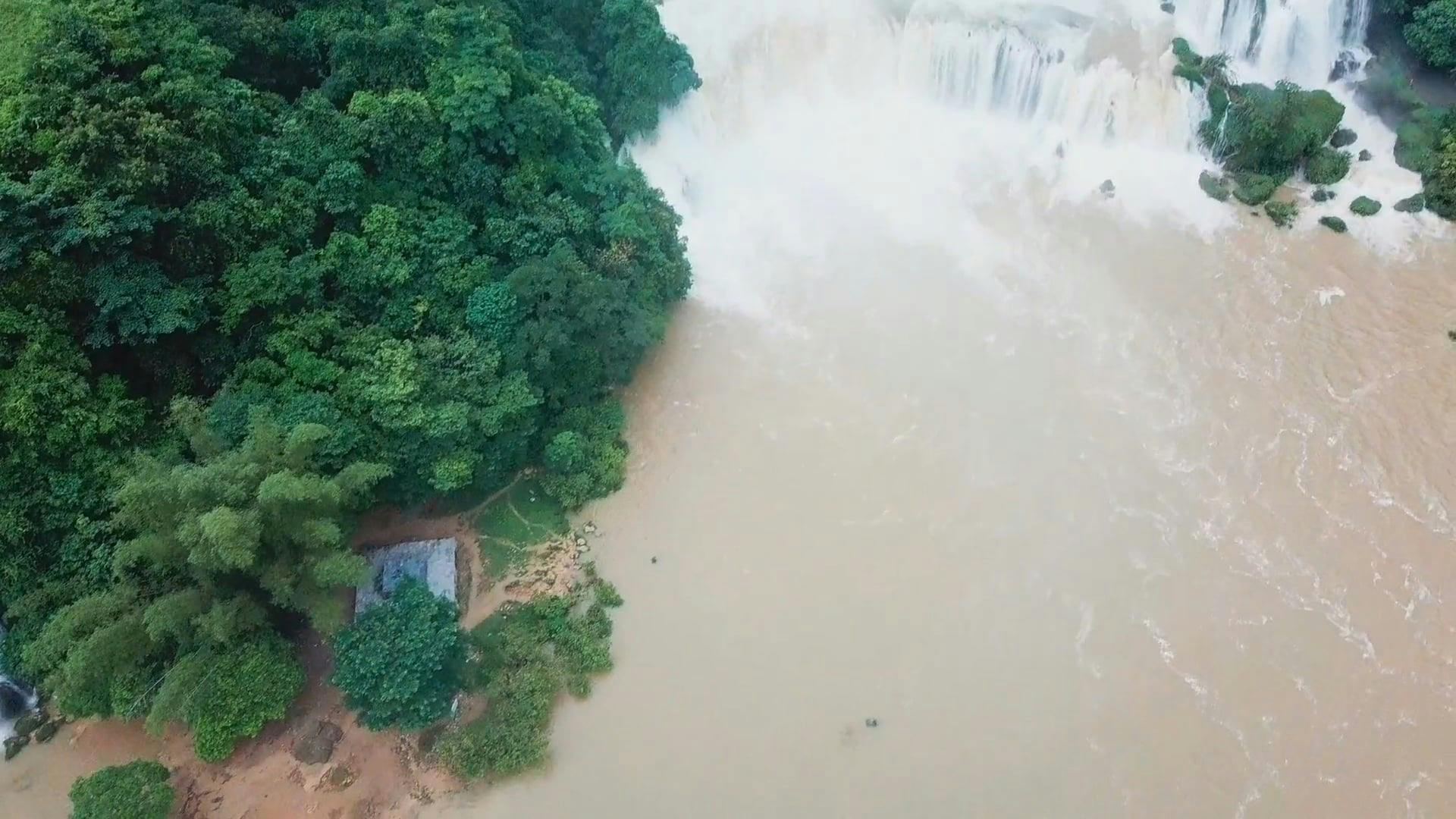 A River Falling Into A Waterfalls Cutting Through The Mountain Forest ...