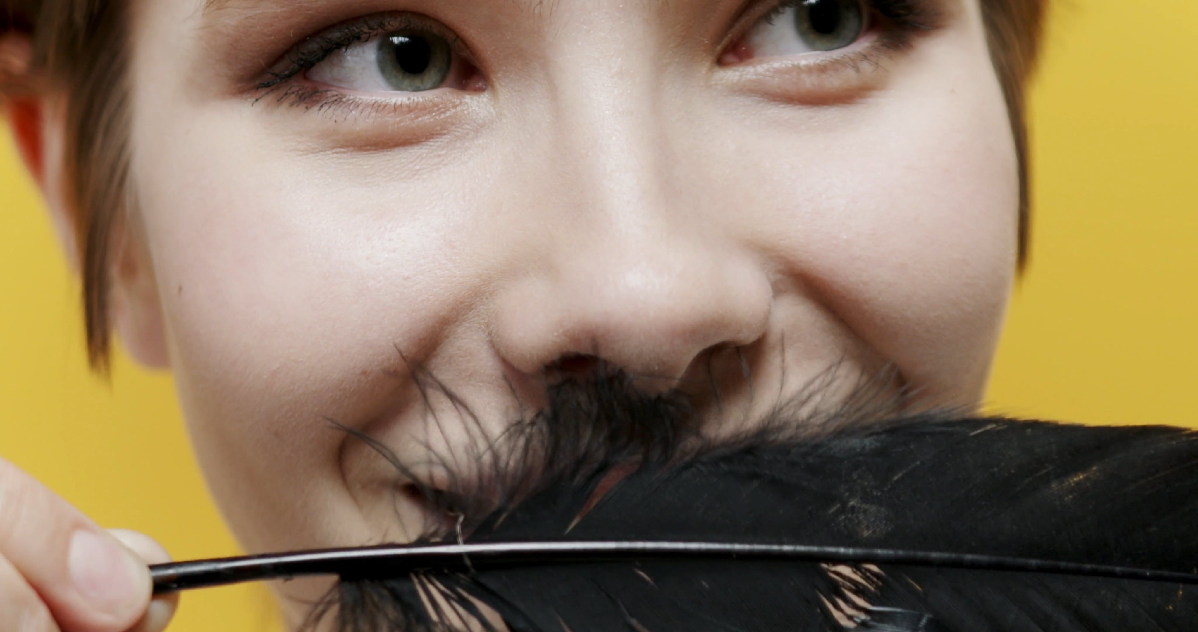 Woman Holding A Feather And Putting It Near Her Nose Free Stock Video ...