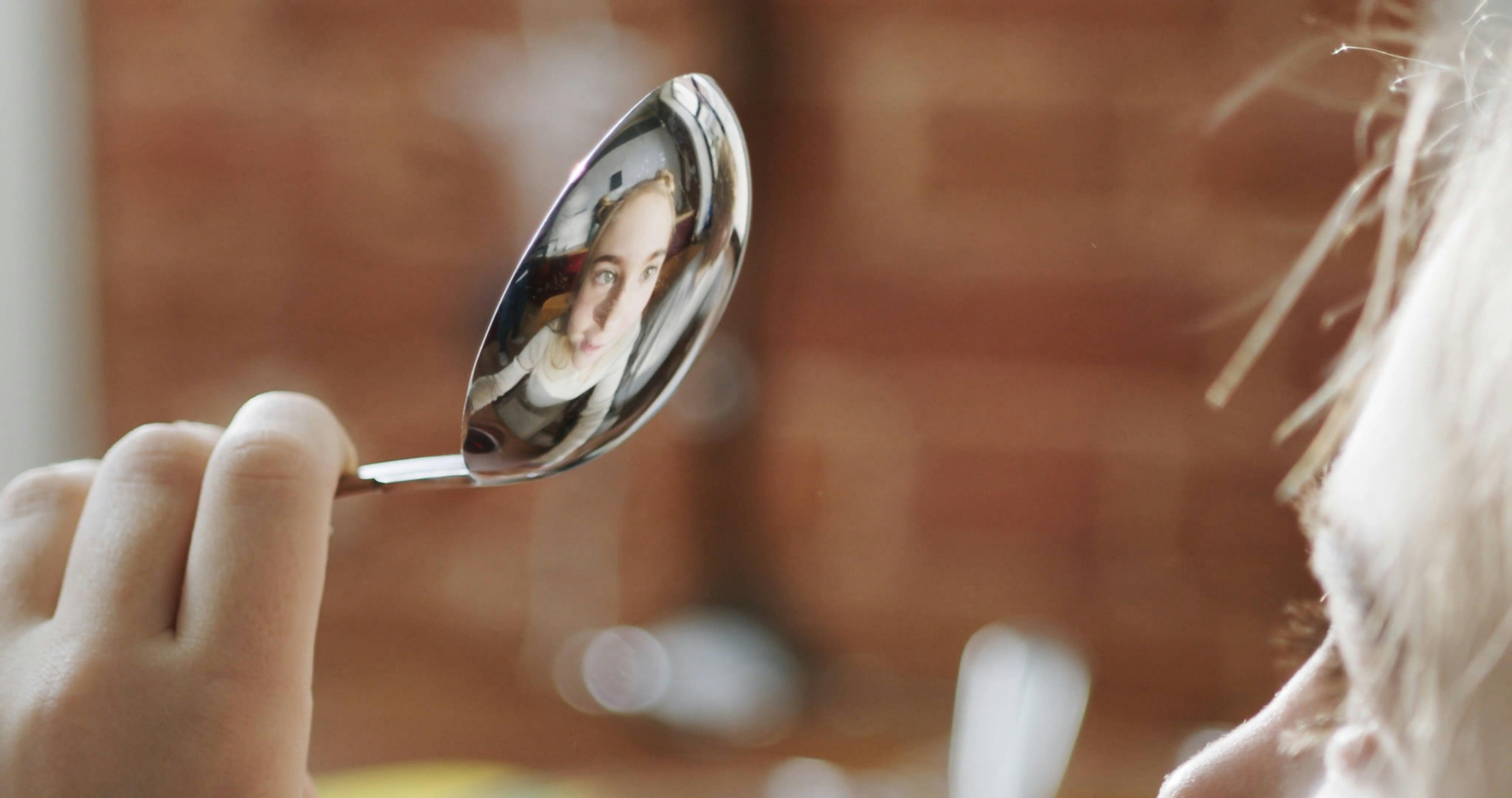 A Girl Using Stainless Spoon As A Mirror Free Stock Video Footage ...