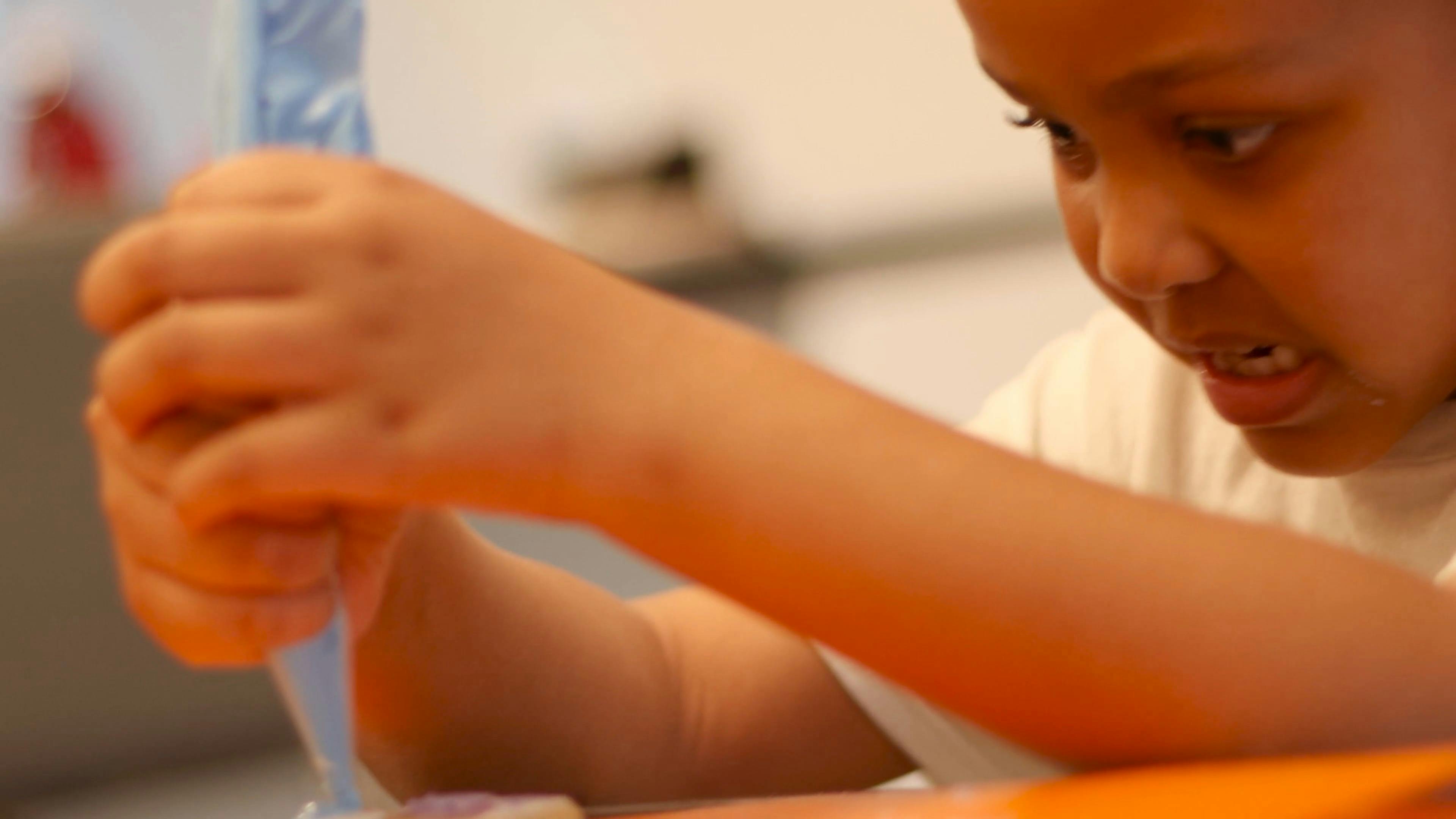 A Child Putting Icing on a Cookie · Free Stock Video