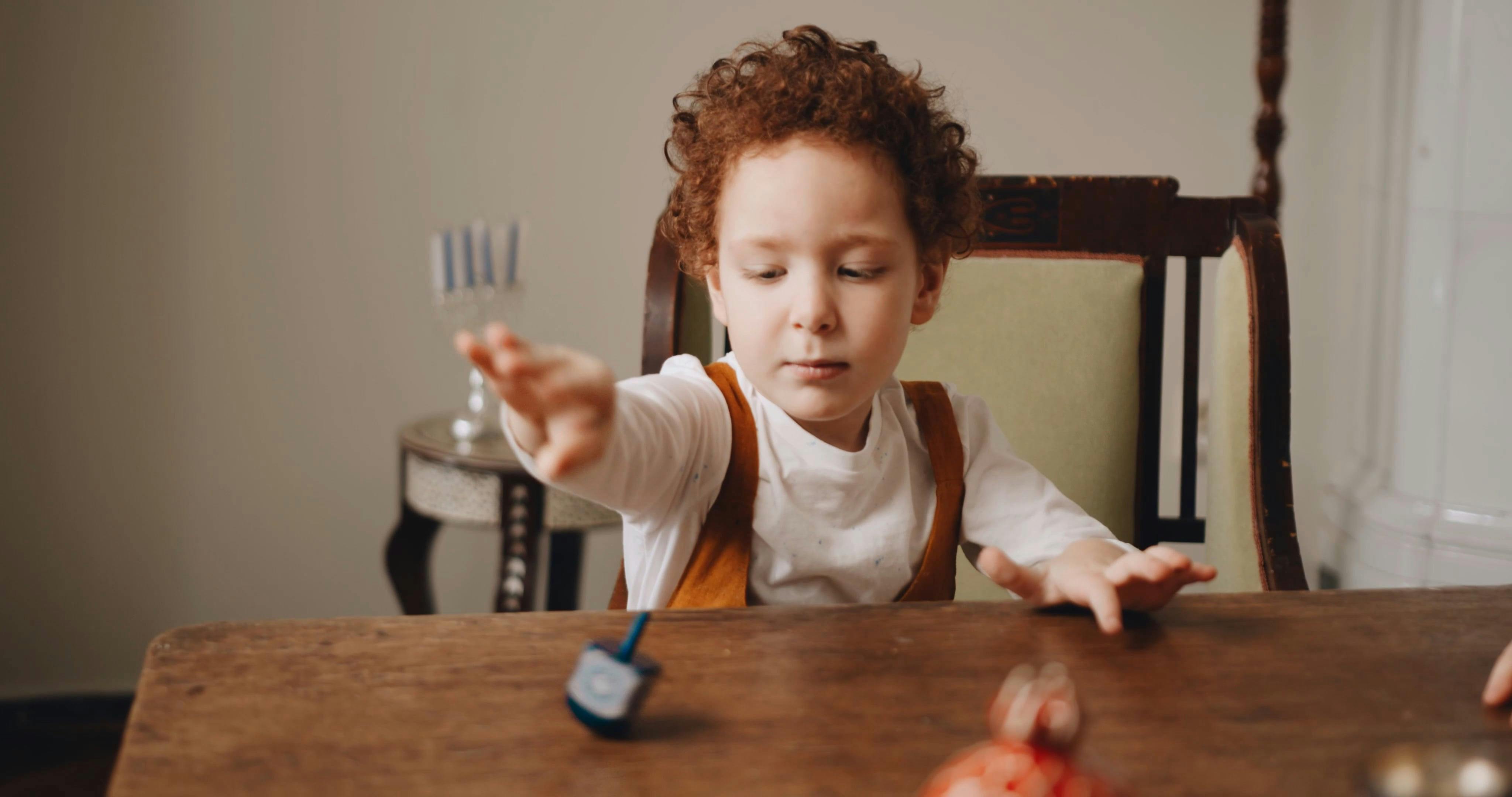 A Boy Playing A Spinning Top Over The Dining Table · Free Stock Video