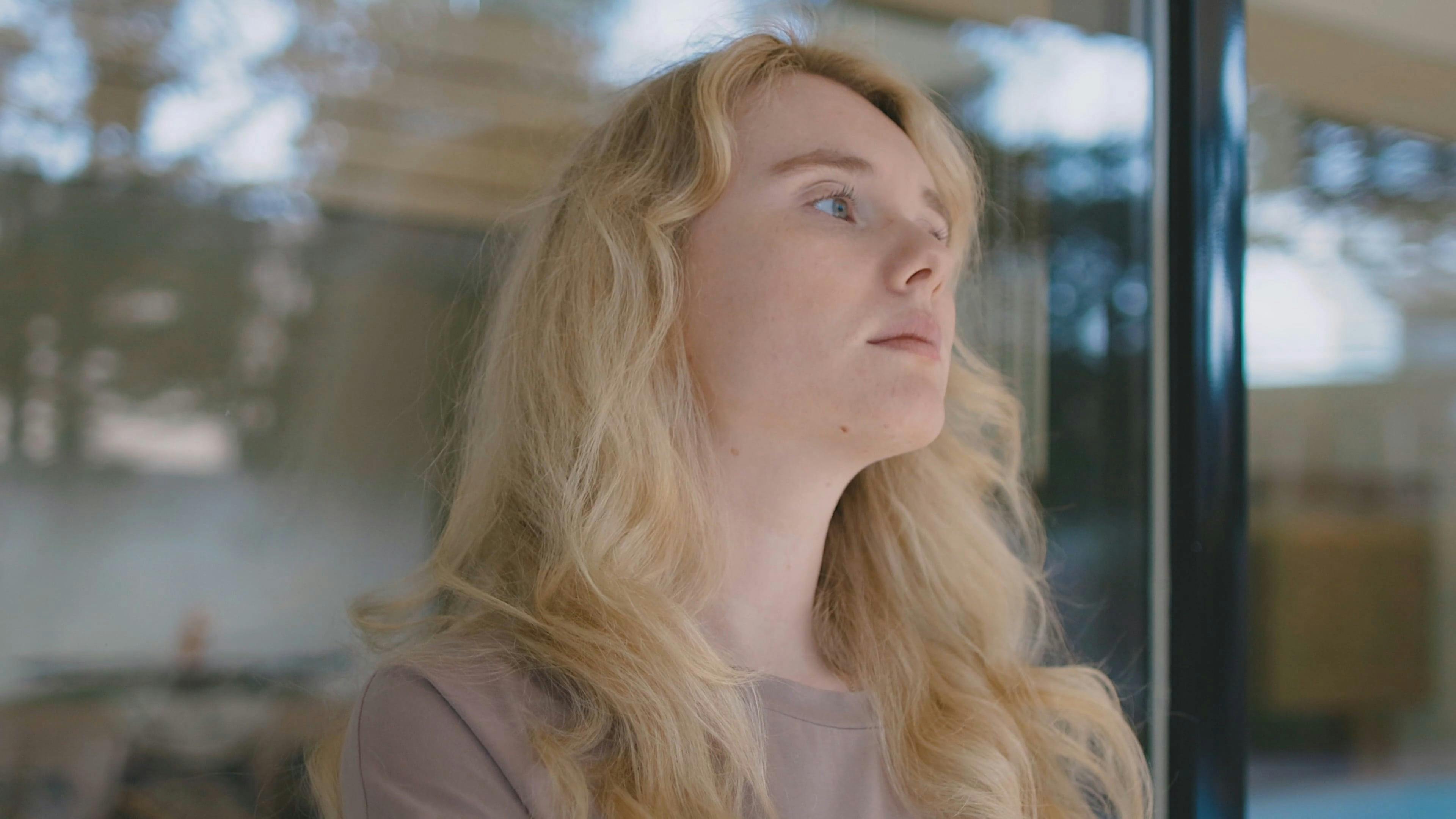 Blond Woman in front of a Window · Free Stock Video