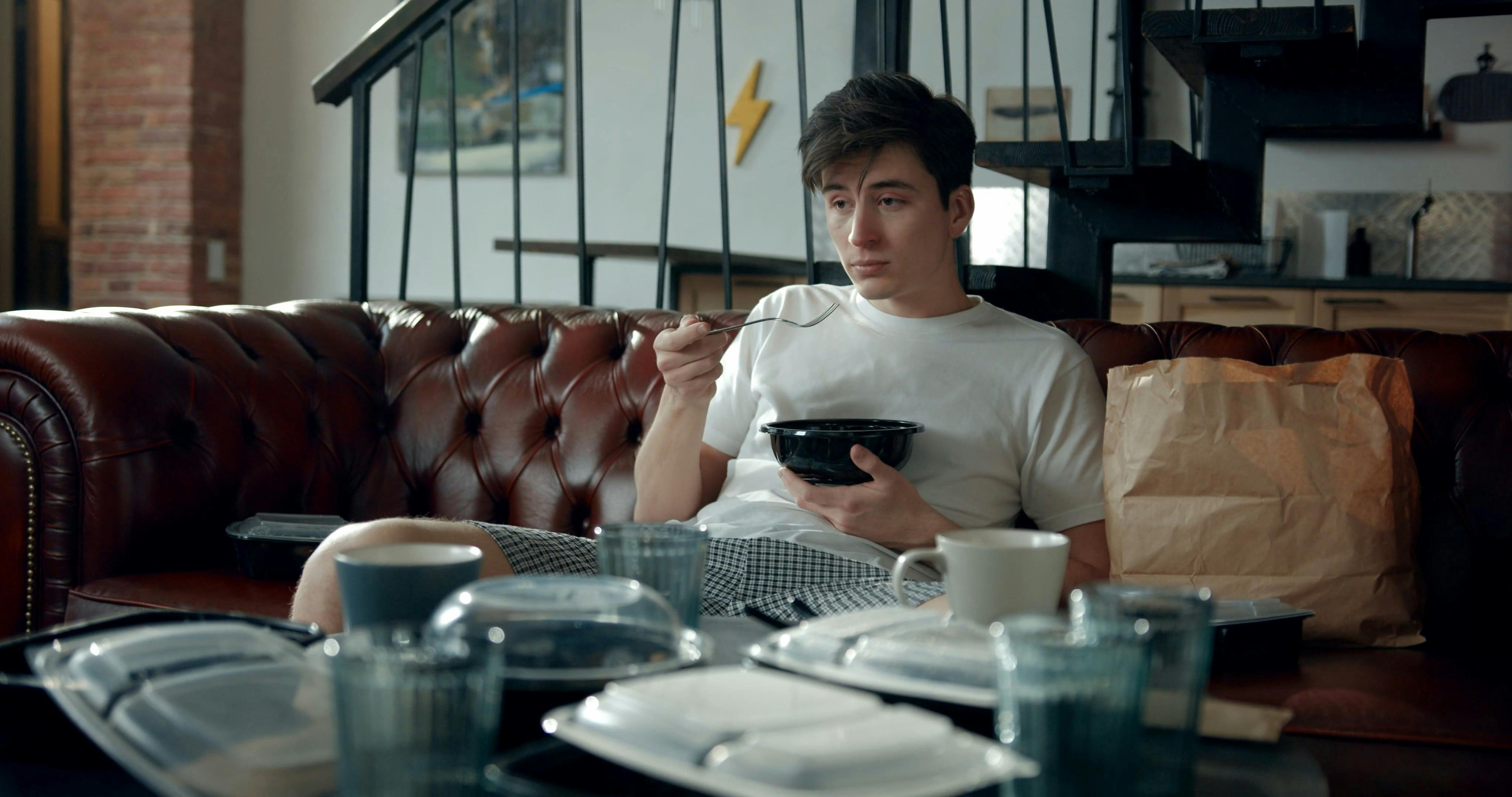 A Man Eating Alone On A Couch Free Stock Video Footage, Royalty-Free 4K ...