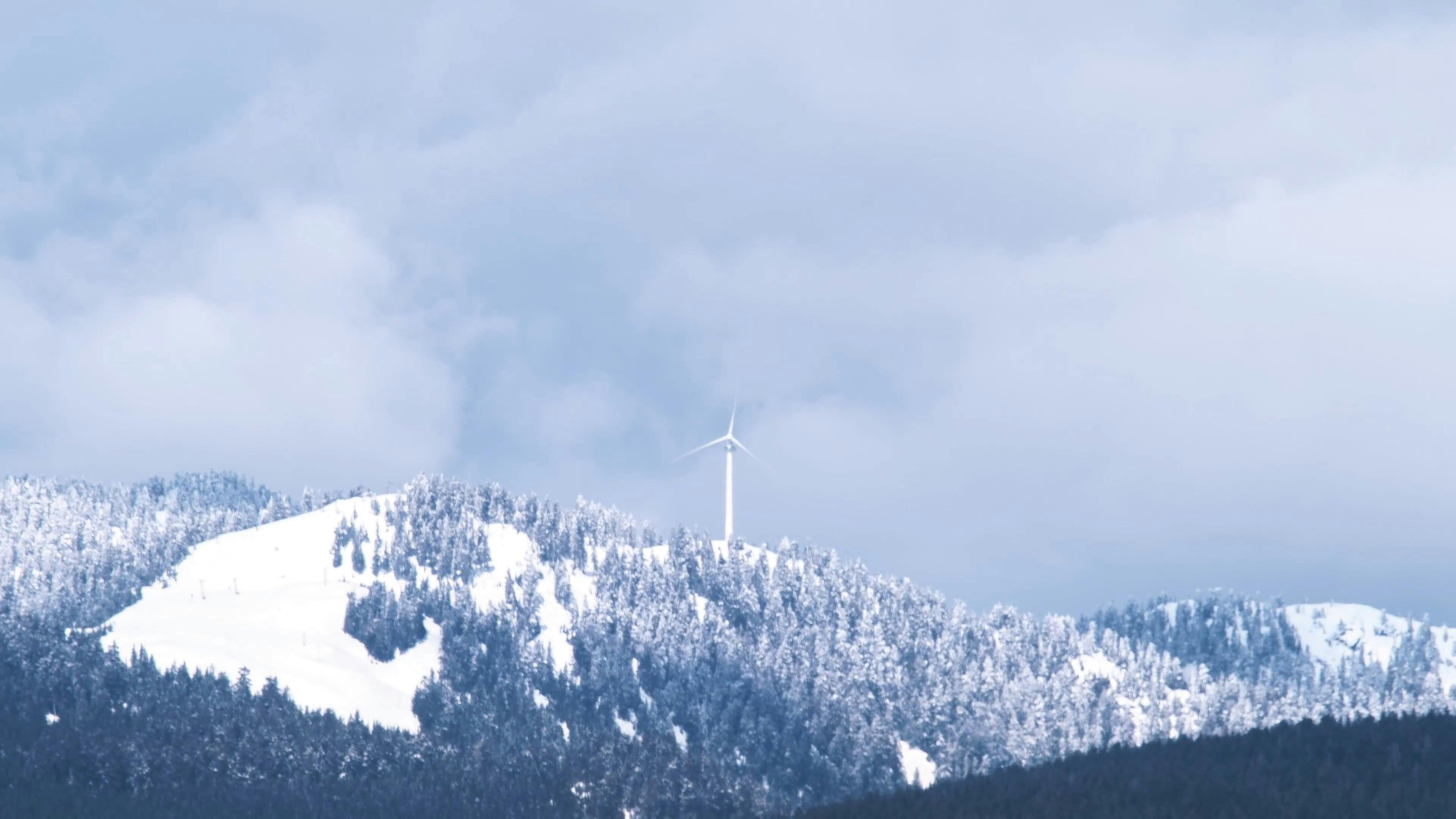 A Windmill On Top Of A Snow Capped Mountain · Free Stock Video