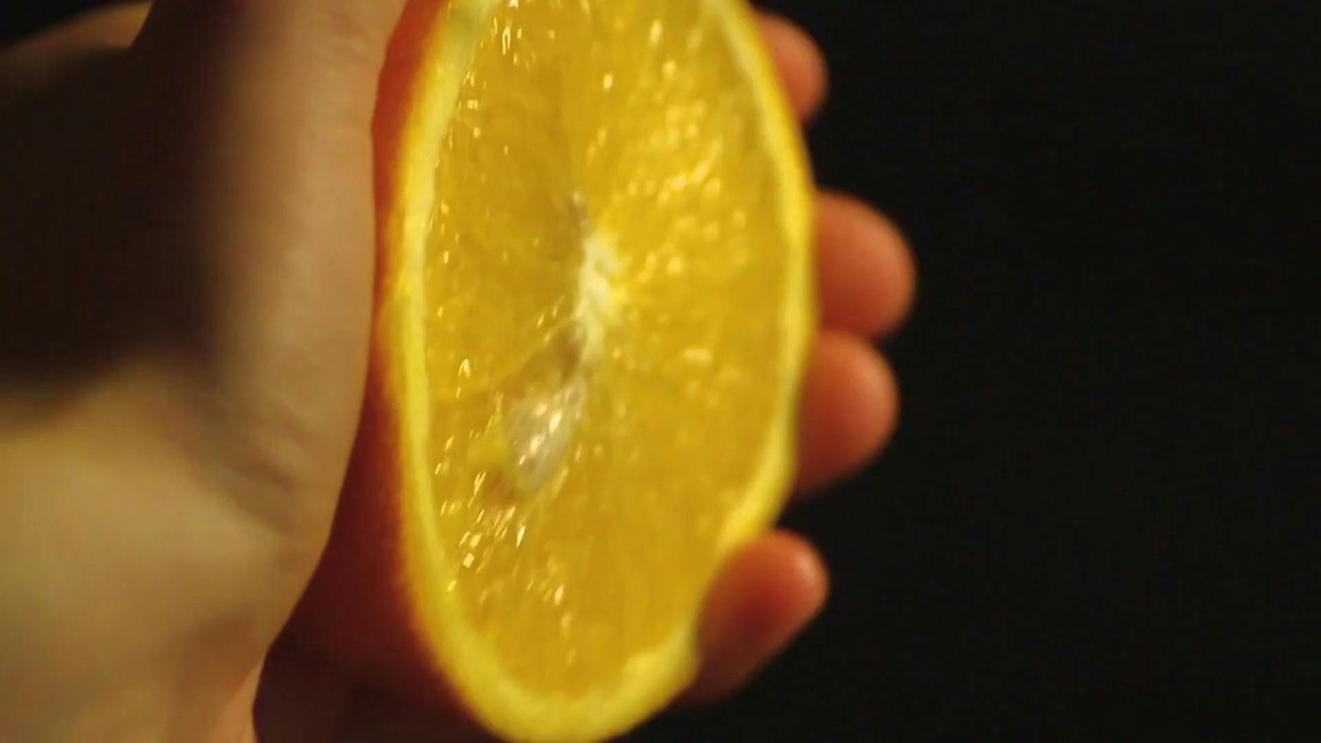 A Person Squeezing an Orange · Free Stock Video
