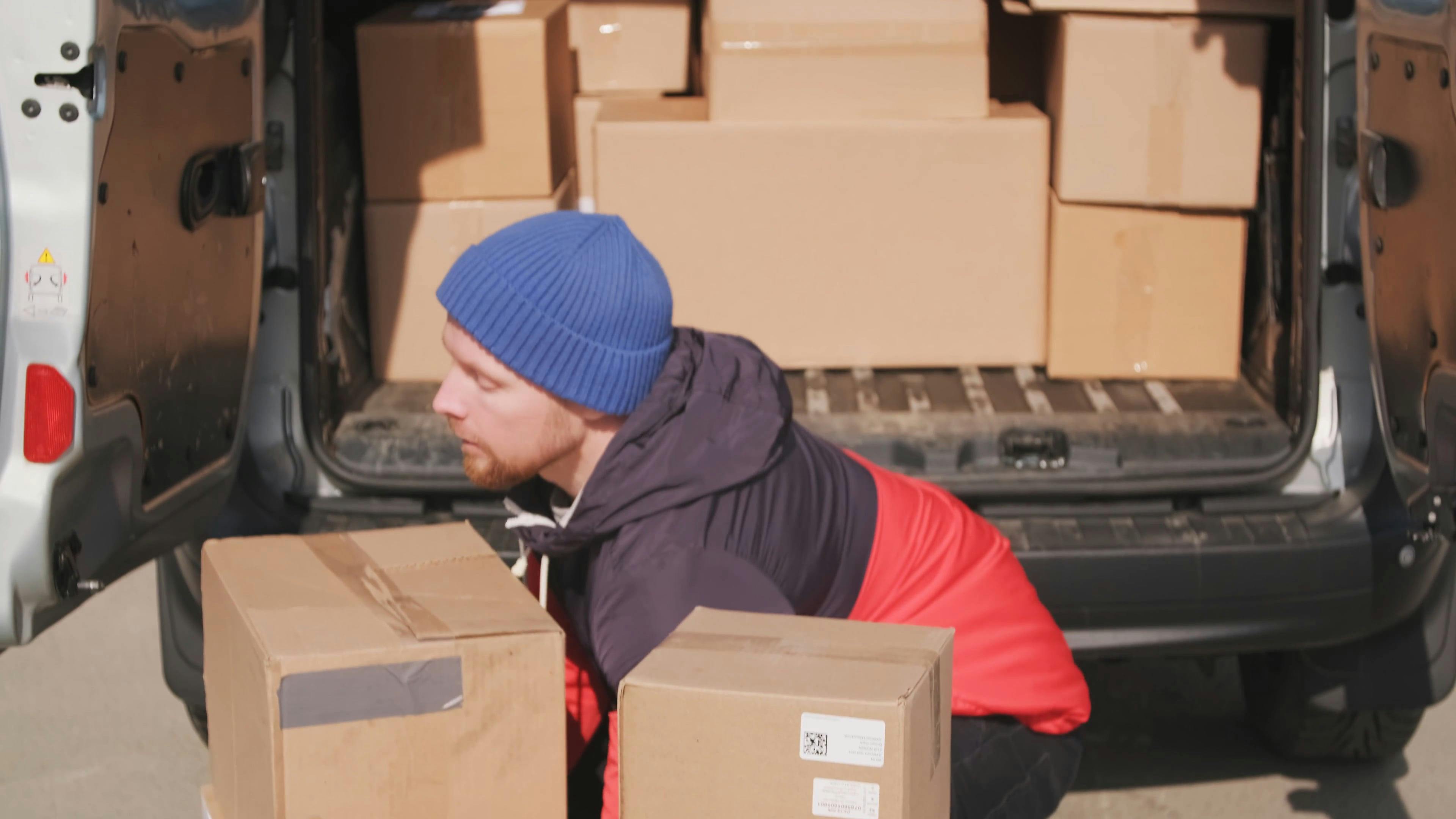 A Man Placing the Boxes inside the Car · Free Stock Video
