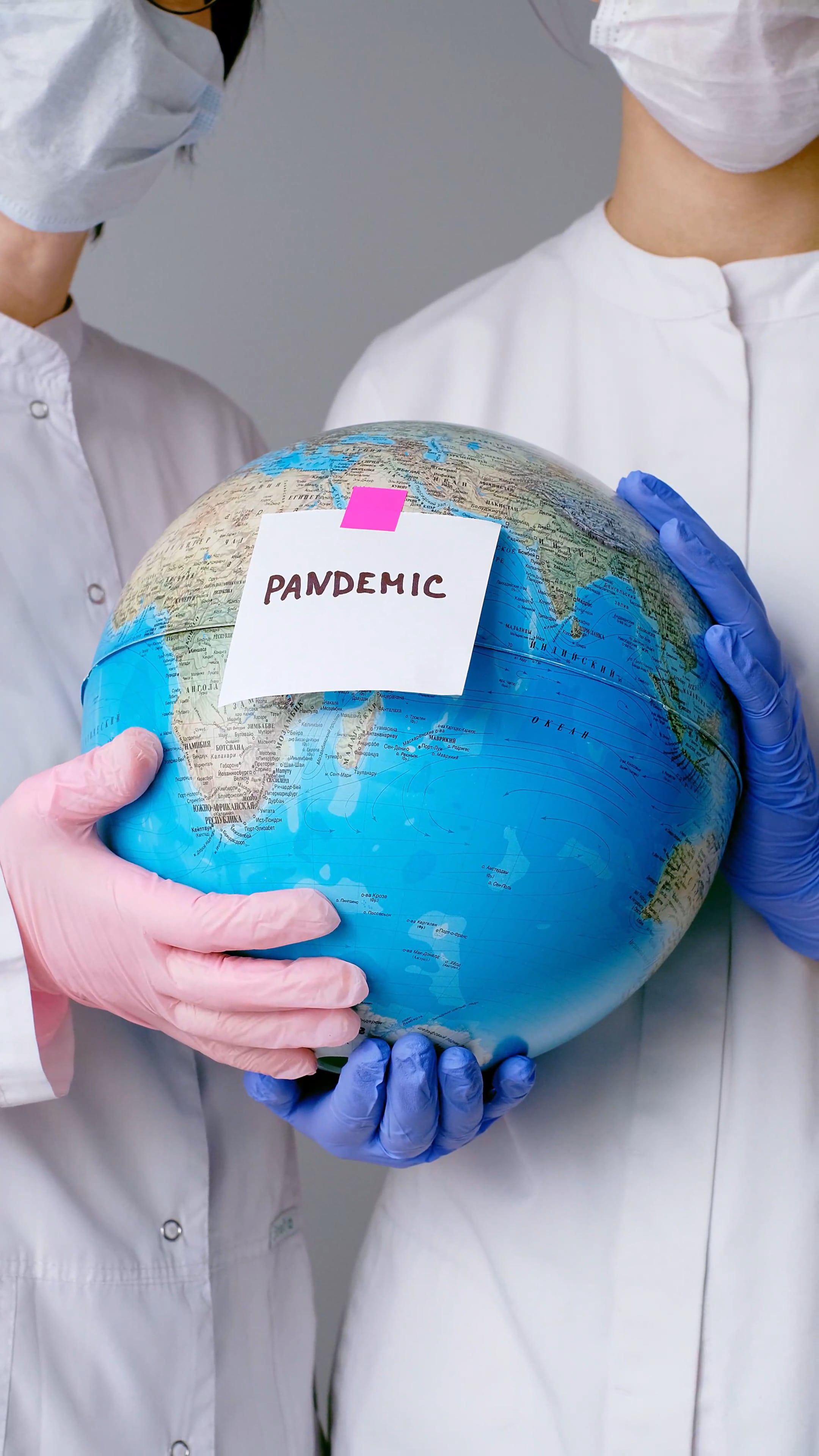 People With Face Masks and Latex Gloves Holding a Globe · Free Stock Video