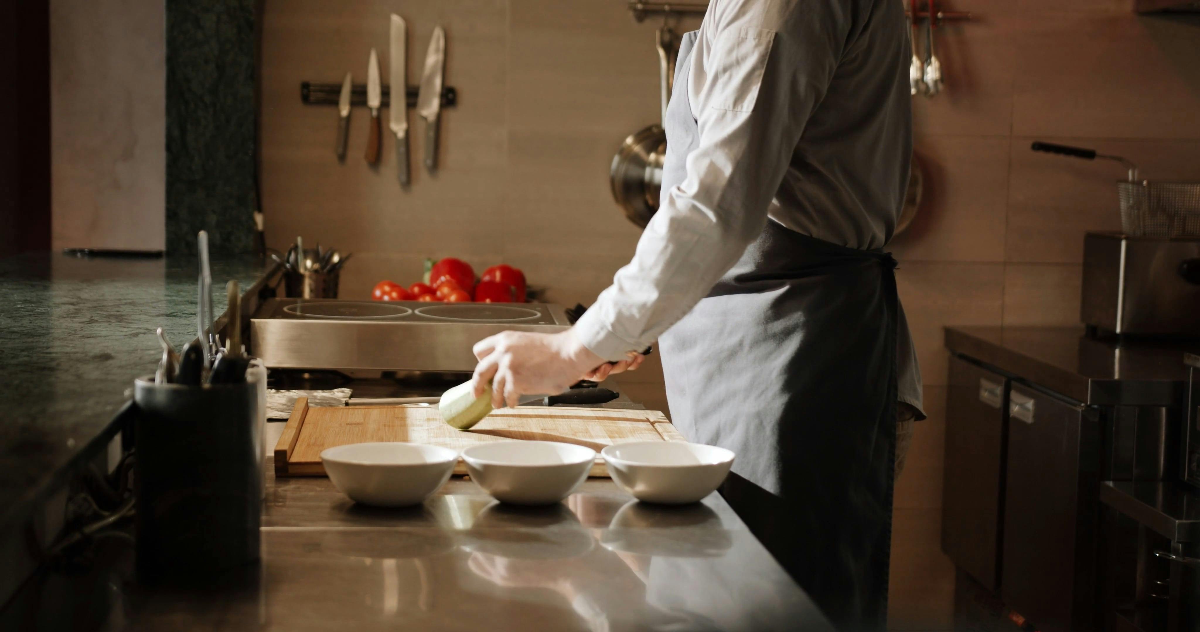 A man in a chef's uniform is cooking in a kitchen Free Stock Video ...