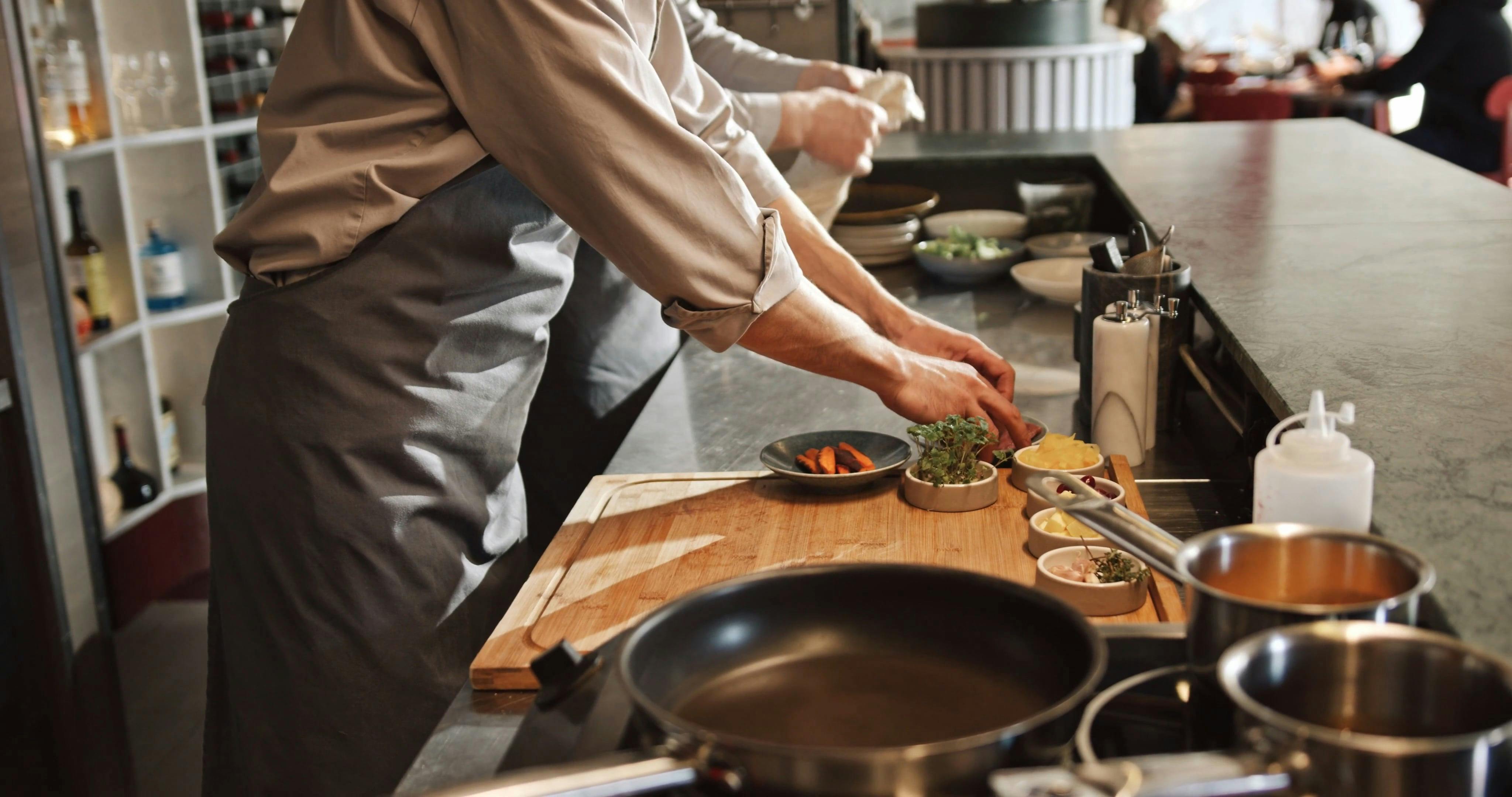 A man in an apron cooking food in a kitchen Free Stock Video Footage ...