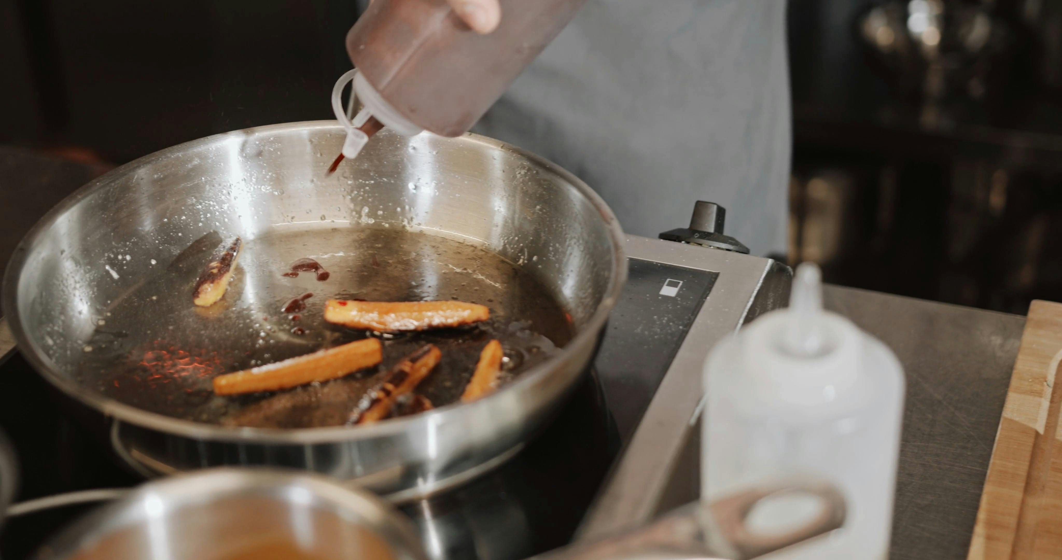 A person cooking food in a pan on a stove Free Stock Video Footage ...