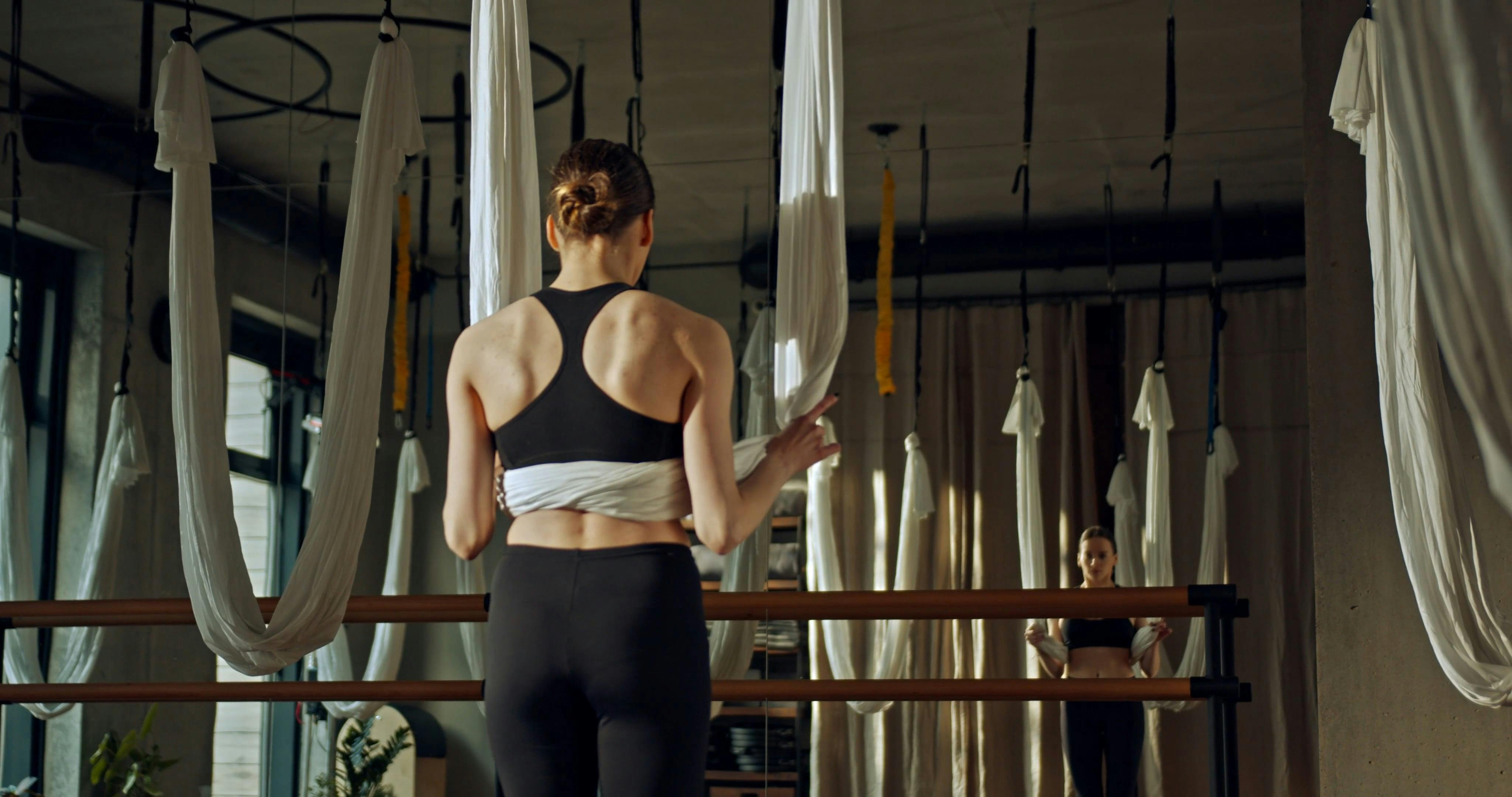 A Woman Balancing On Her Back Over A Hanging Fabric Free Stock Video ...