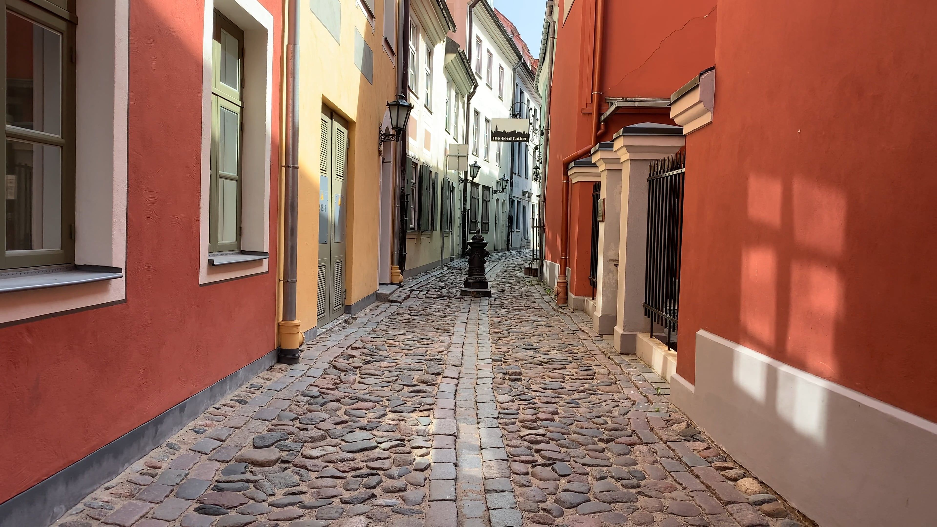 A Group Of People Walking In A Cobblestone Alley With Assorted Pendant ...