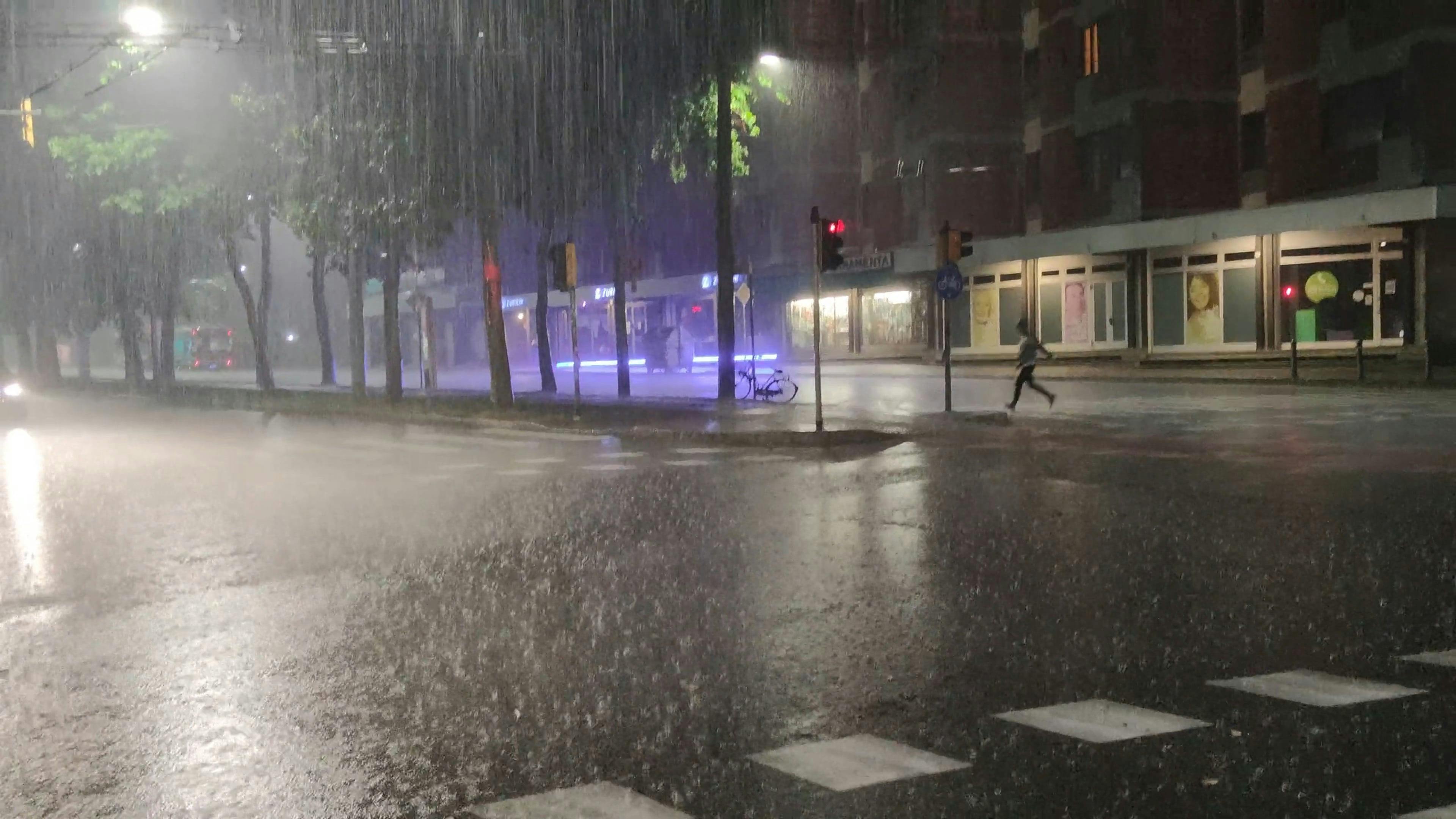 A Person Crossing the Street in the Pouring Rain · Free Stock Video