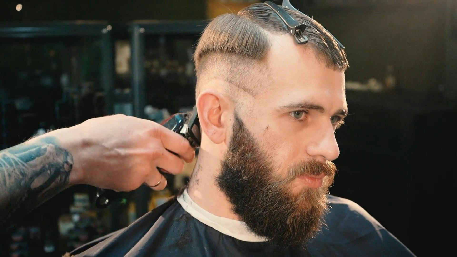A Barber Using An Electric Shaver To Cut The Hair Of A Man Free Stock ...