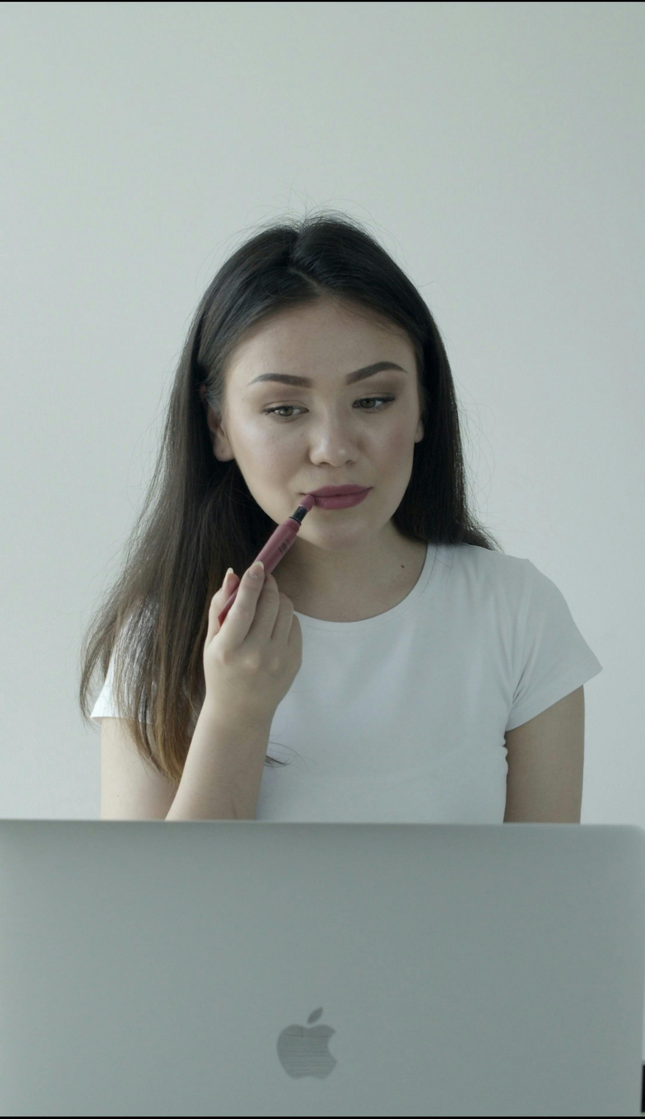 A Woman Applying Lip Color Using A Laptop As Mirror Free Stock Video ...