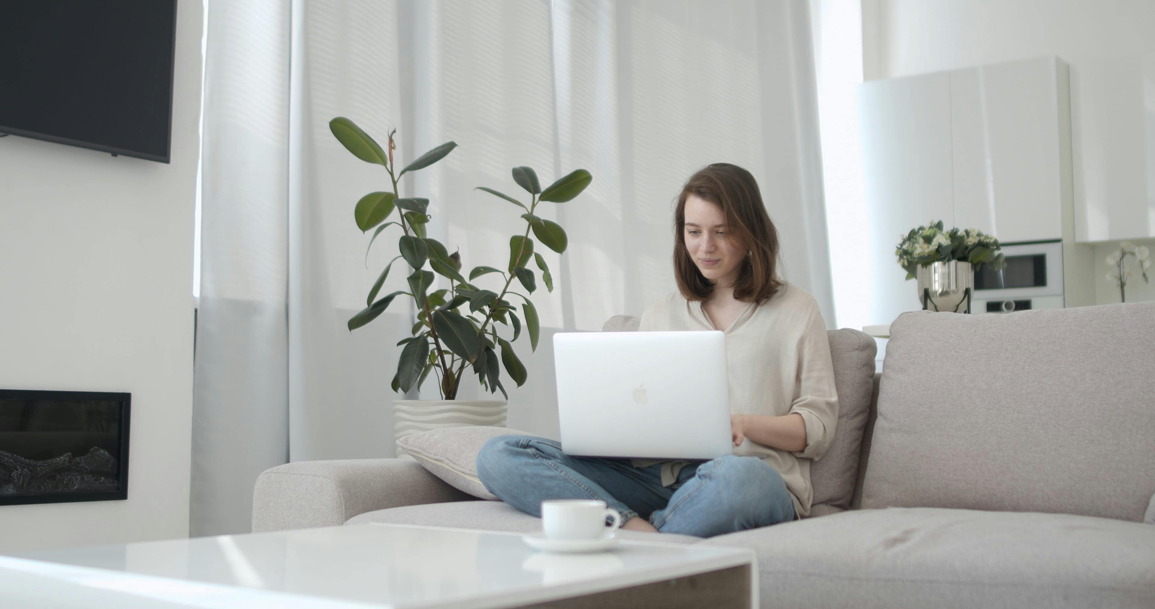 A Woman Sitting on a Couch while Using Her Laptop · Free Stock Video