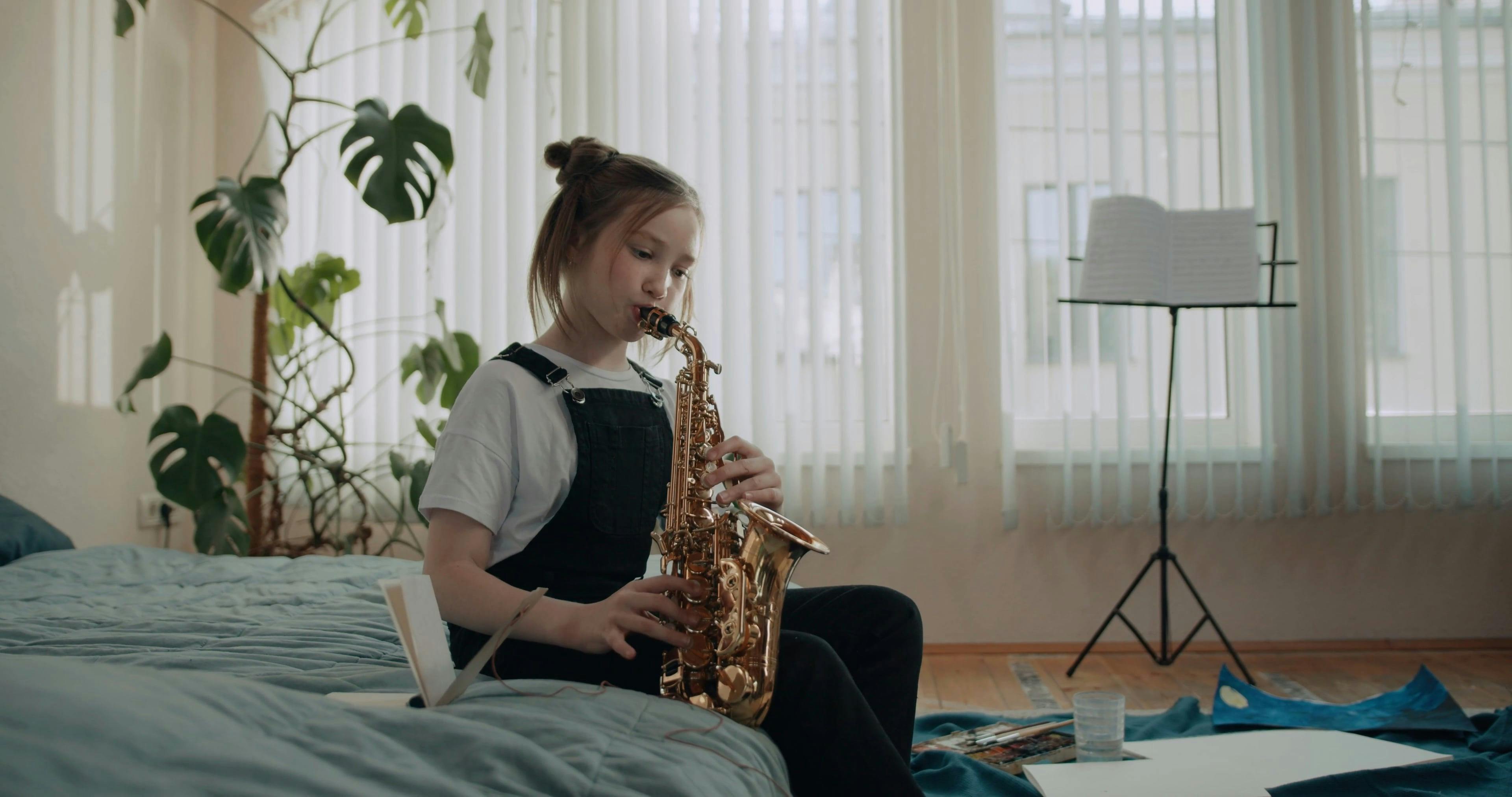 A girl playing the saxophone on a bed Free Stock Video Footage, Royalty ...