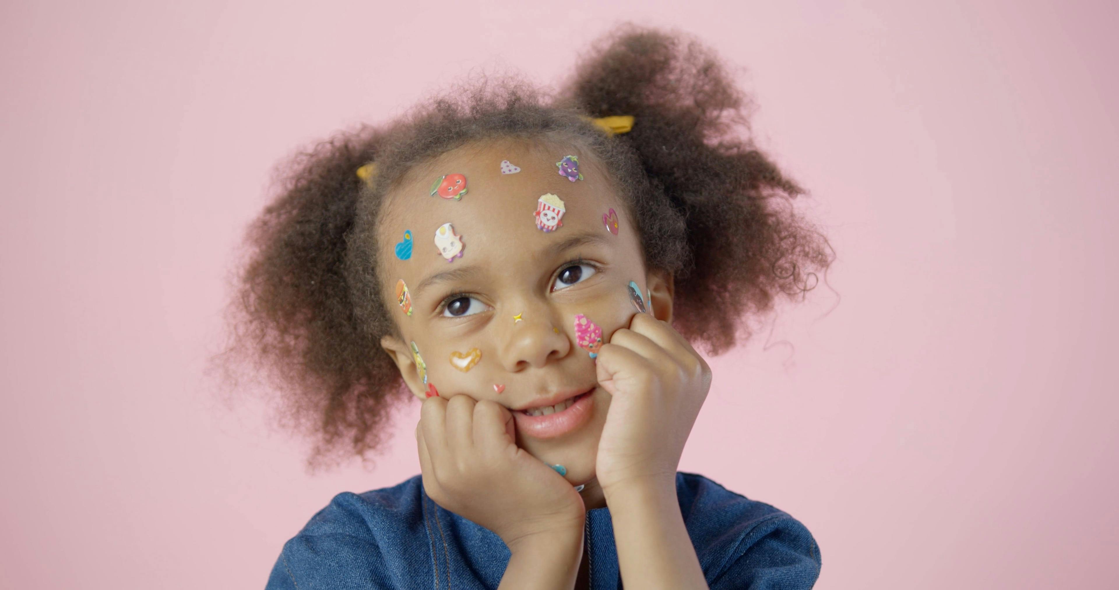 A young girl with a face full of stickers Free Stock Video Footage ...