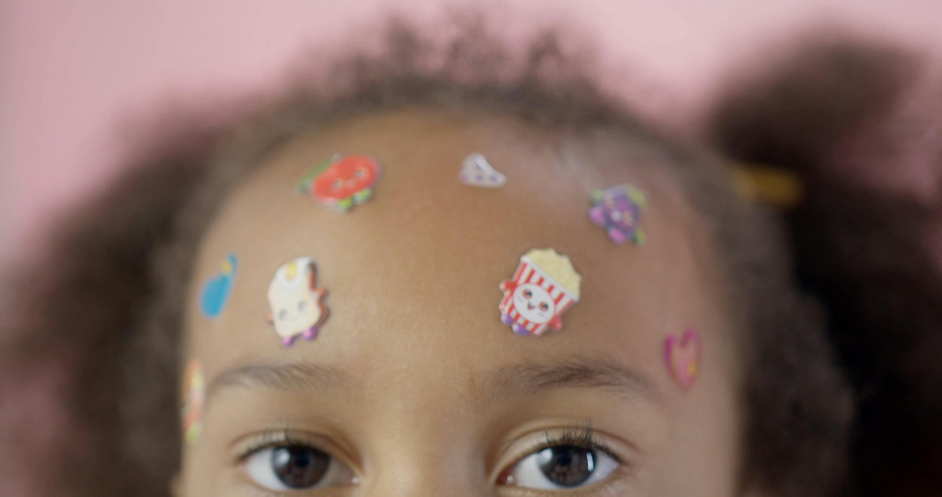 A young girl with stickers on her face Free Stock Video Footage ...