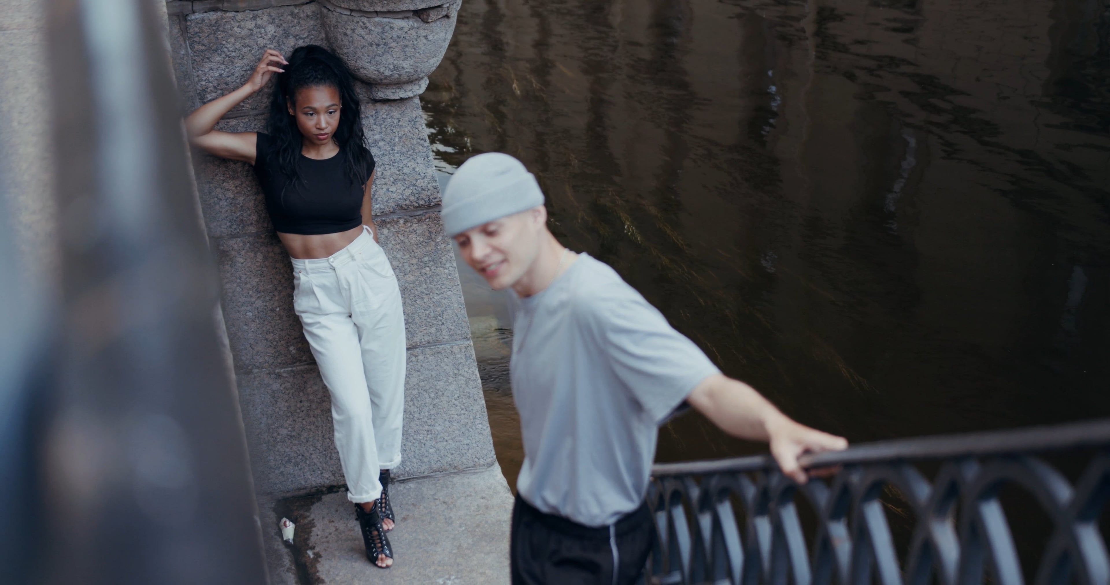 Two people standing on a bridge next to a river Free Stock Video ...