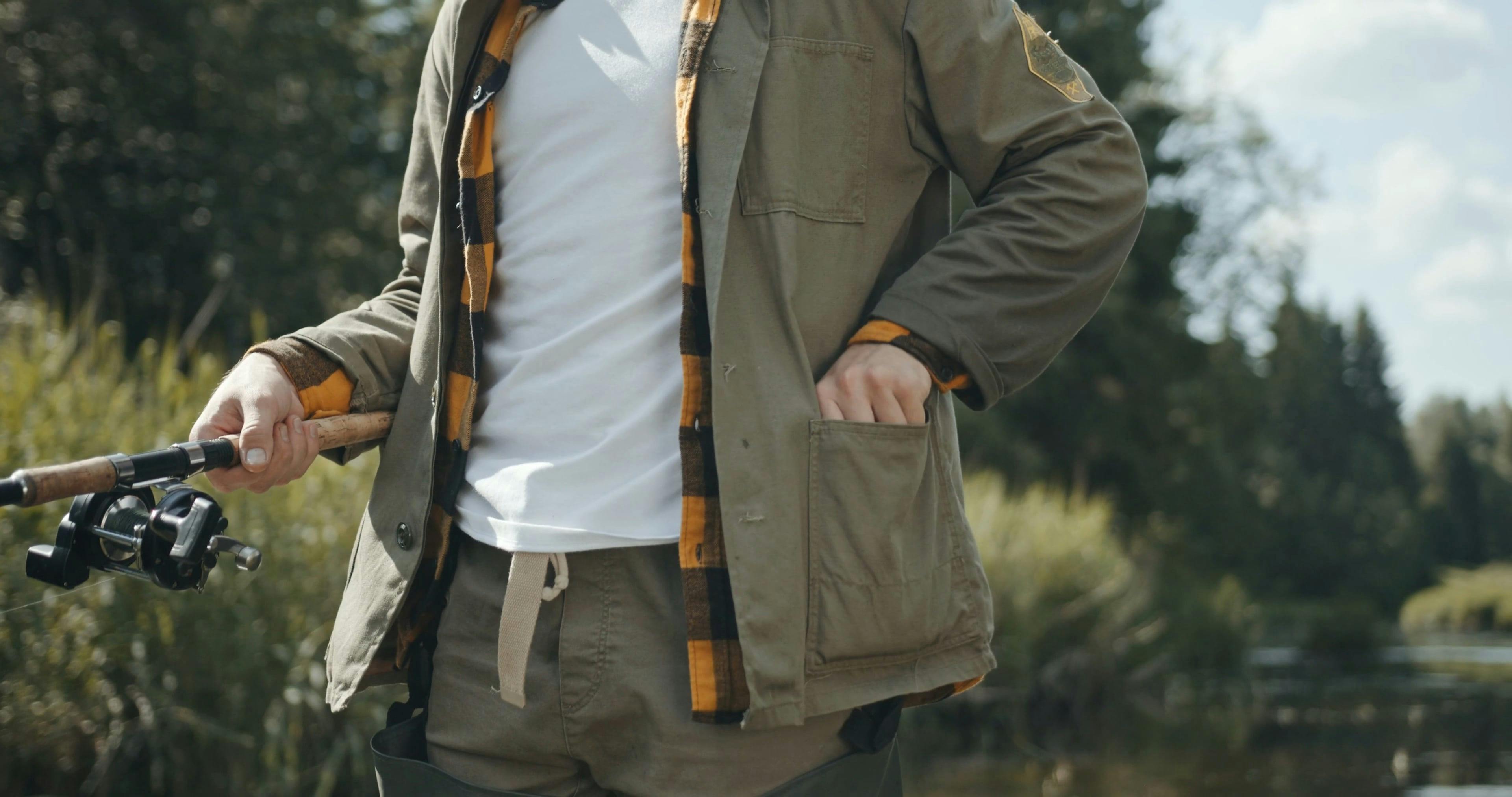 Man Holding His Fishing Rod While Getting His Flask Out of His Pocket ...