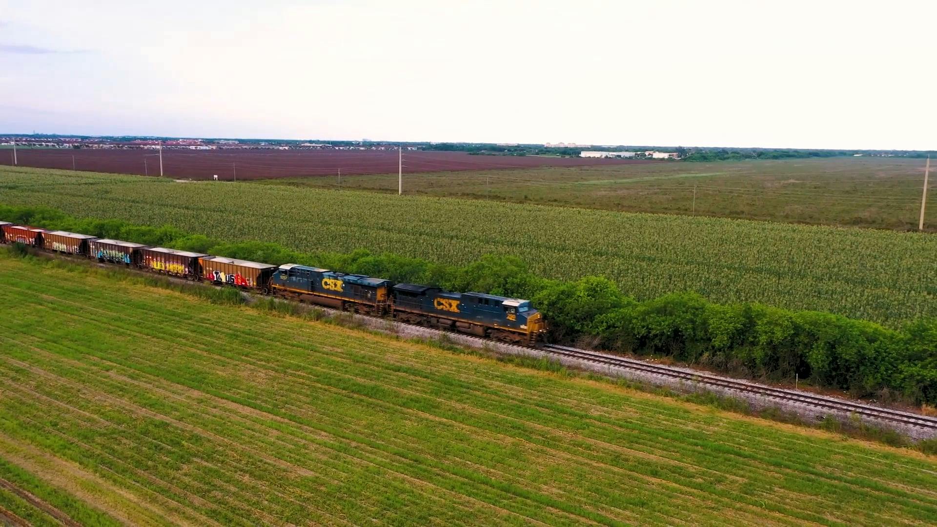 A Train Traveling On A Railroad Crossing A Farm Field Free Stock Video ...