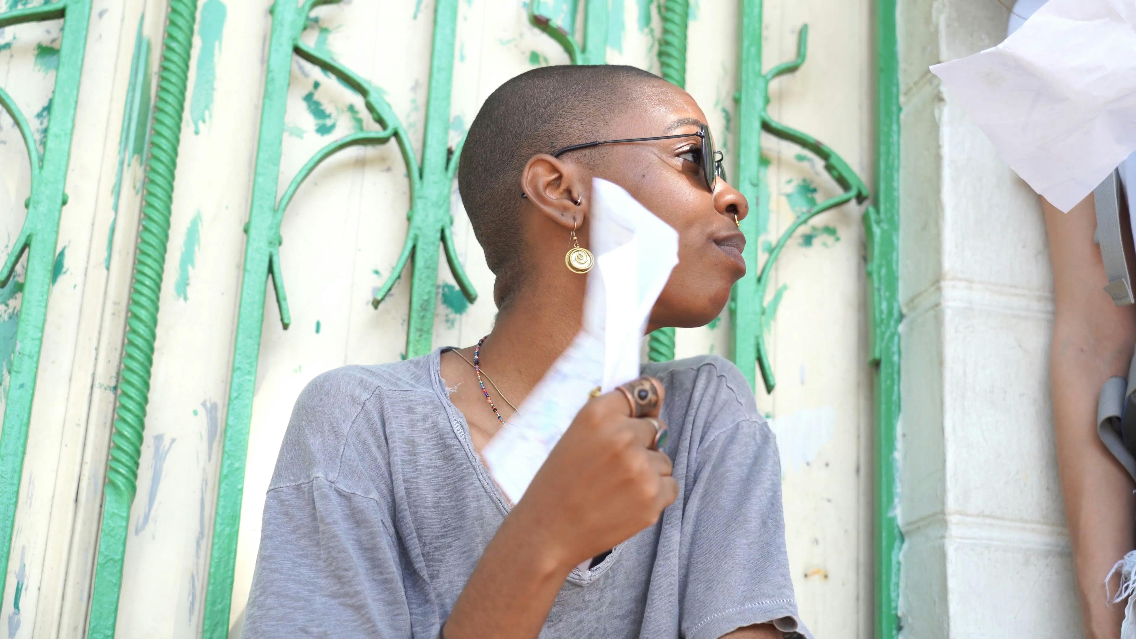 A Woman Fanning Herself with a Map · Free Stock Video