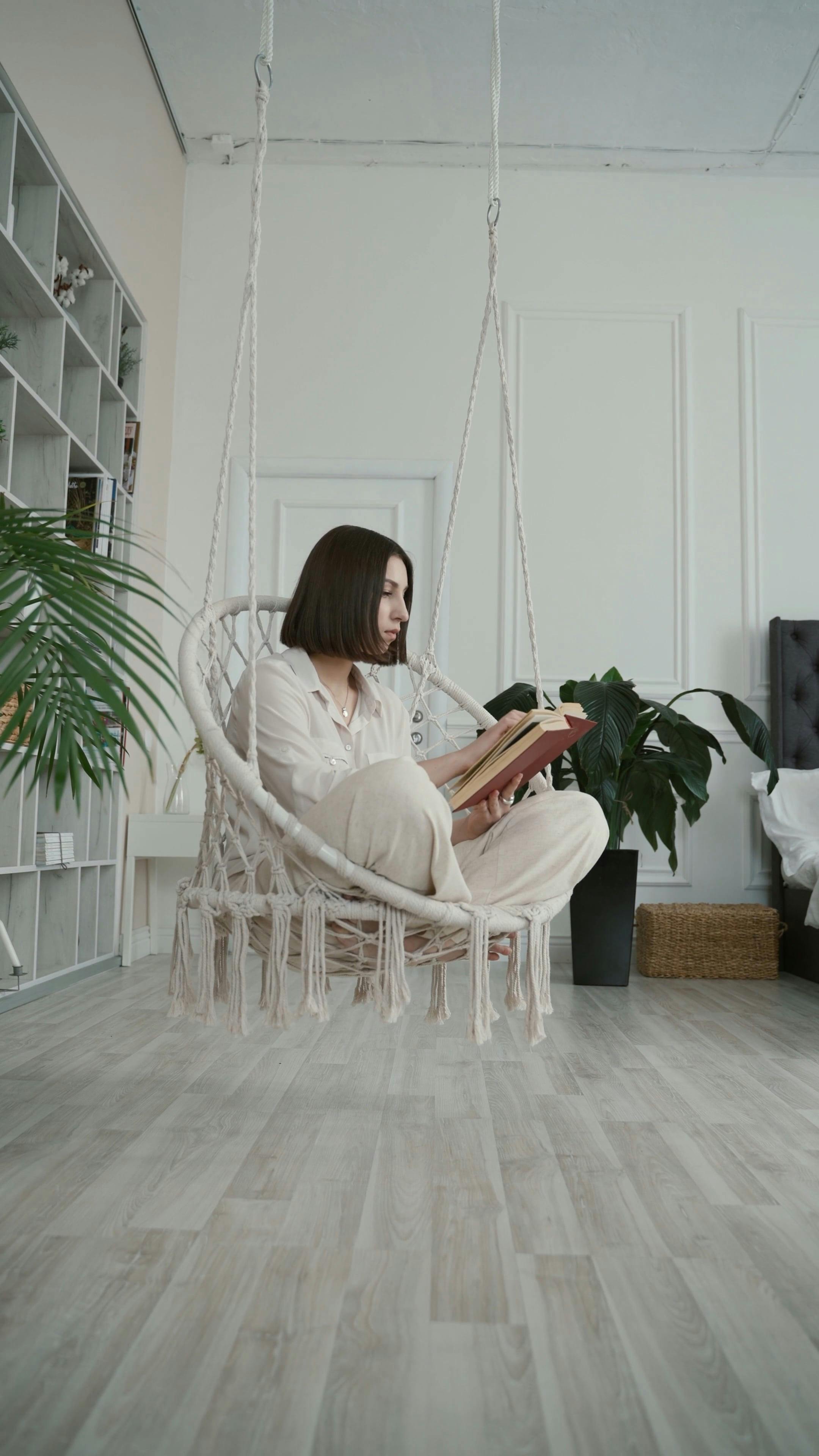 Woman Sitting on Her Indoor Swing while Reading Free Stock Video ...