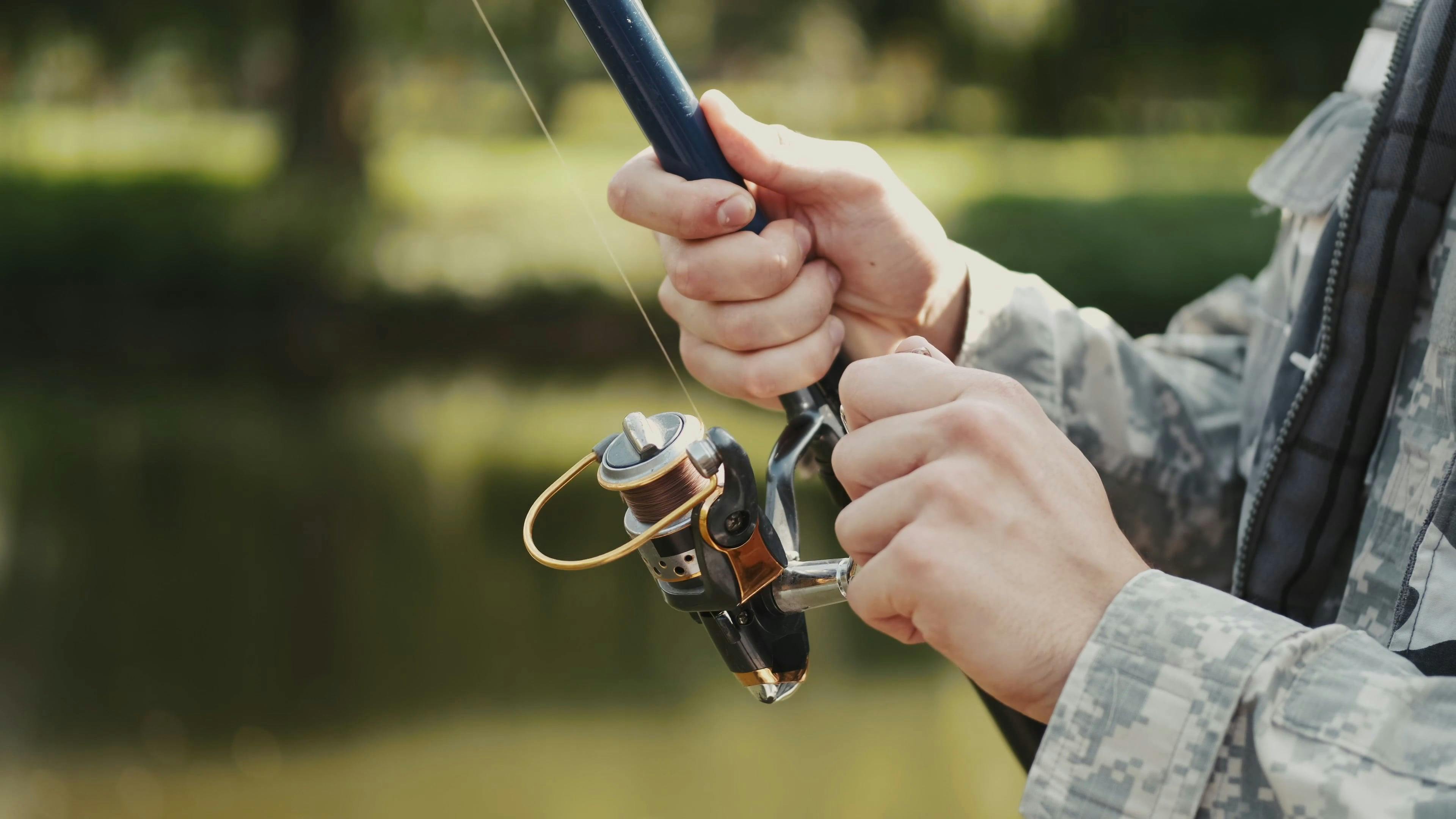 Shallow Focus of Person Reeling in Fishing Line · Free Stock Video