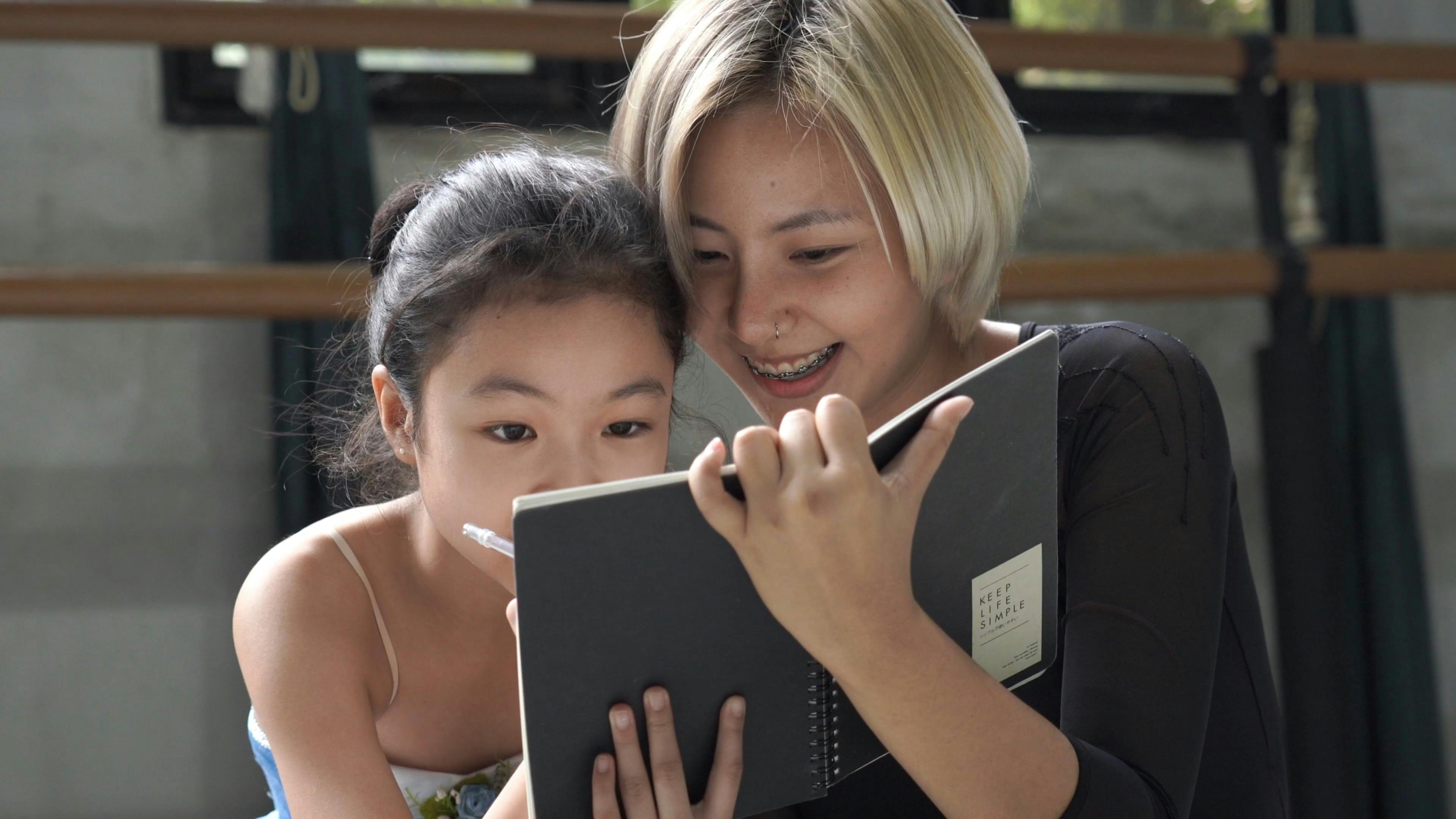 Two Persons Looking at a Notebook While Writing Free Stock Video ...