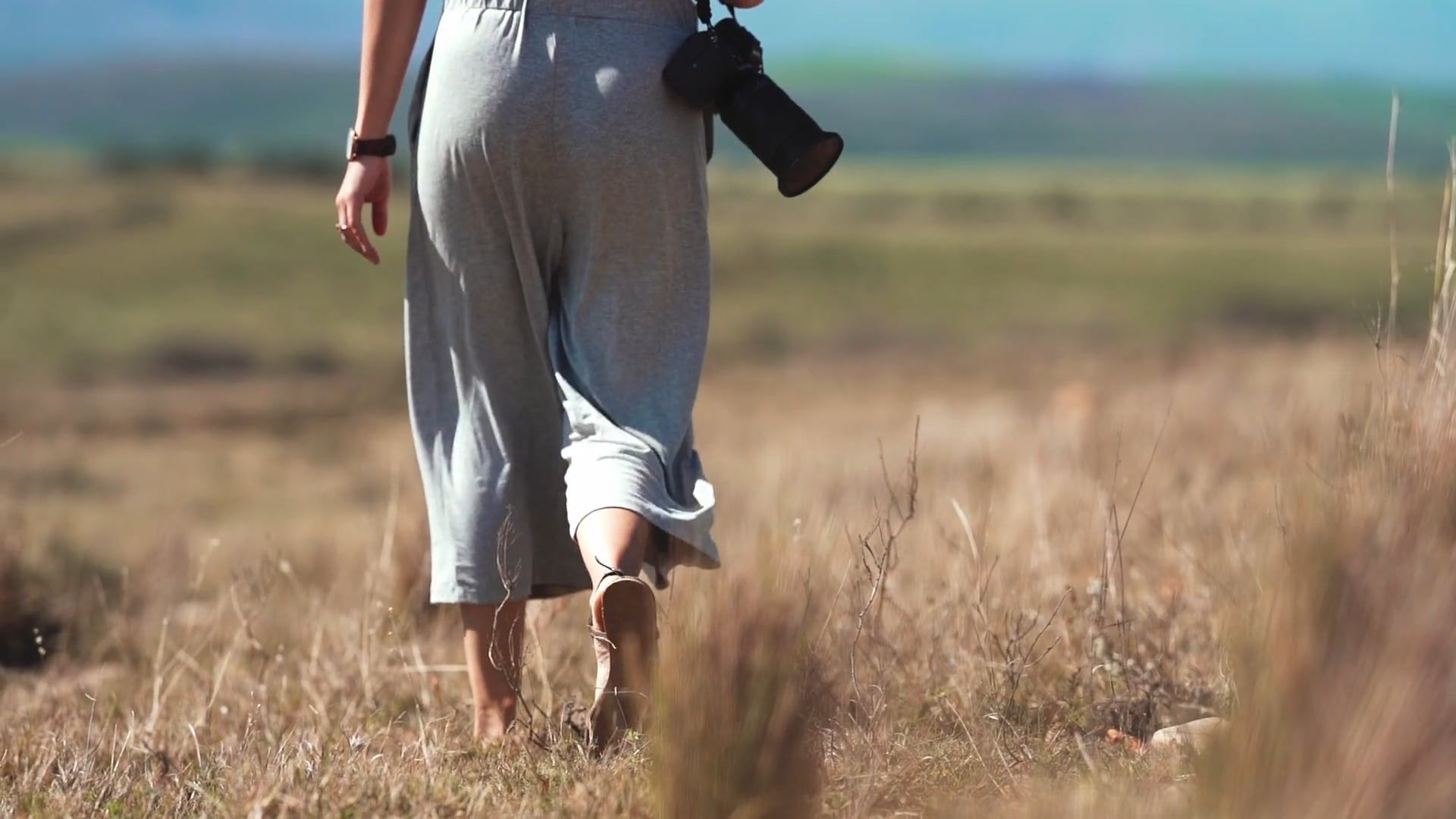 Woman Walking on the Grass Field and Taking Photos · Free Stock Video