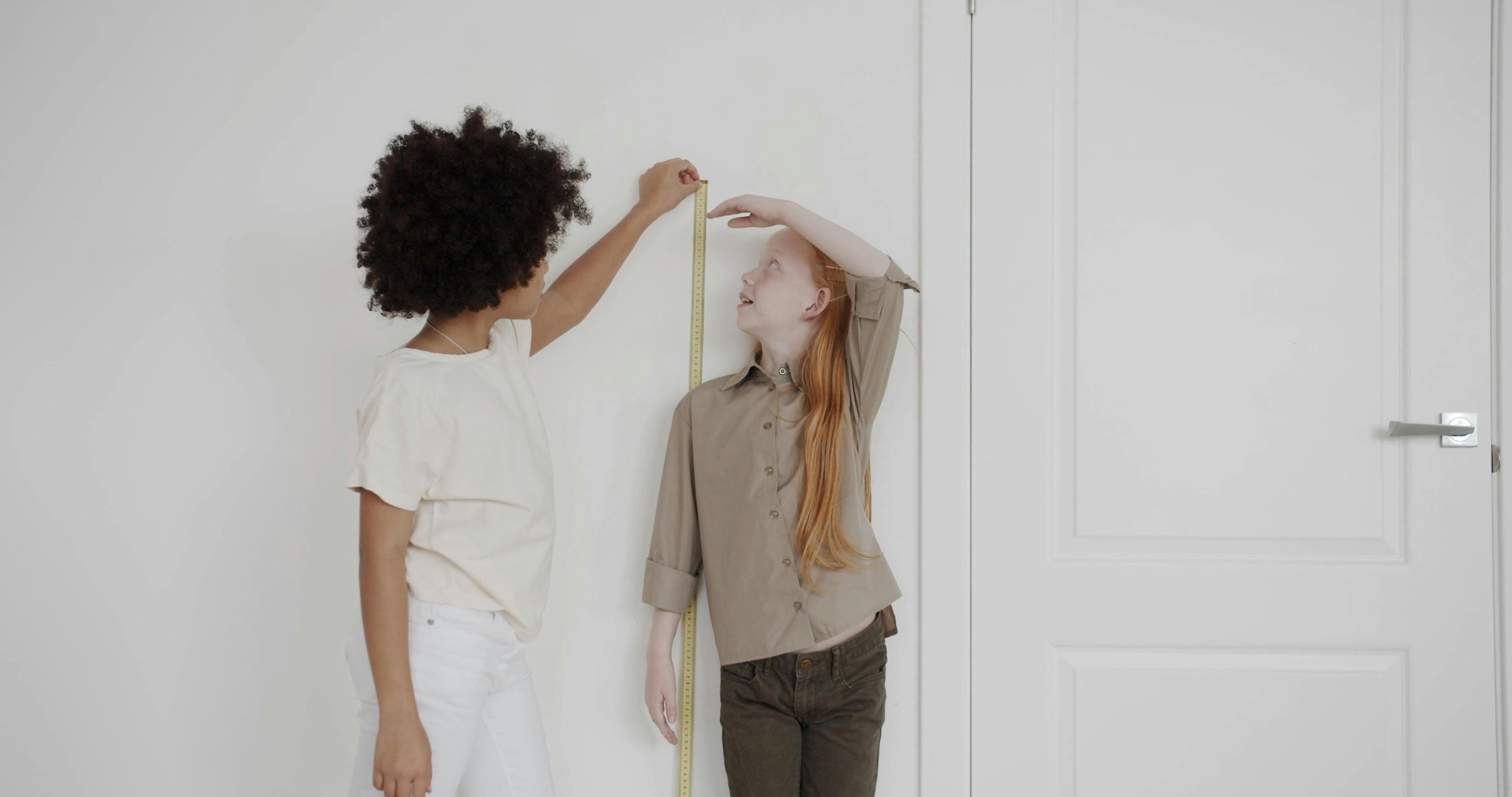 Girl Measuring Height of Another Girl · Free Stock Video