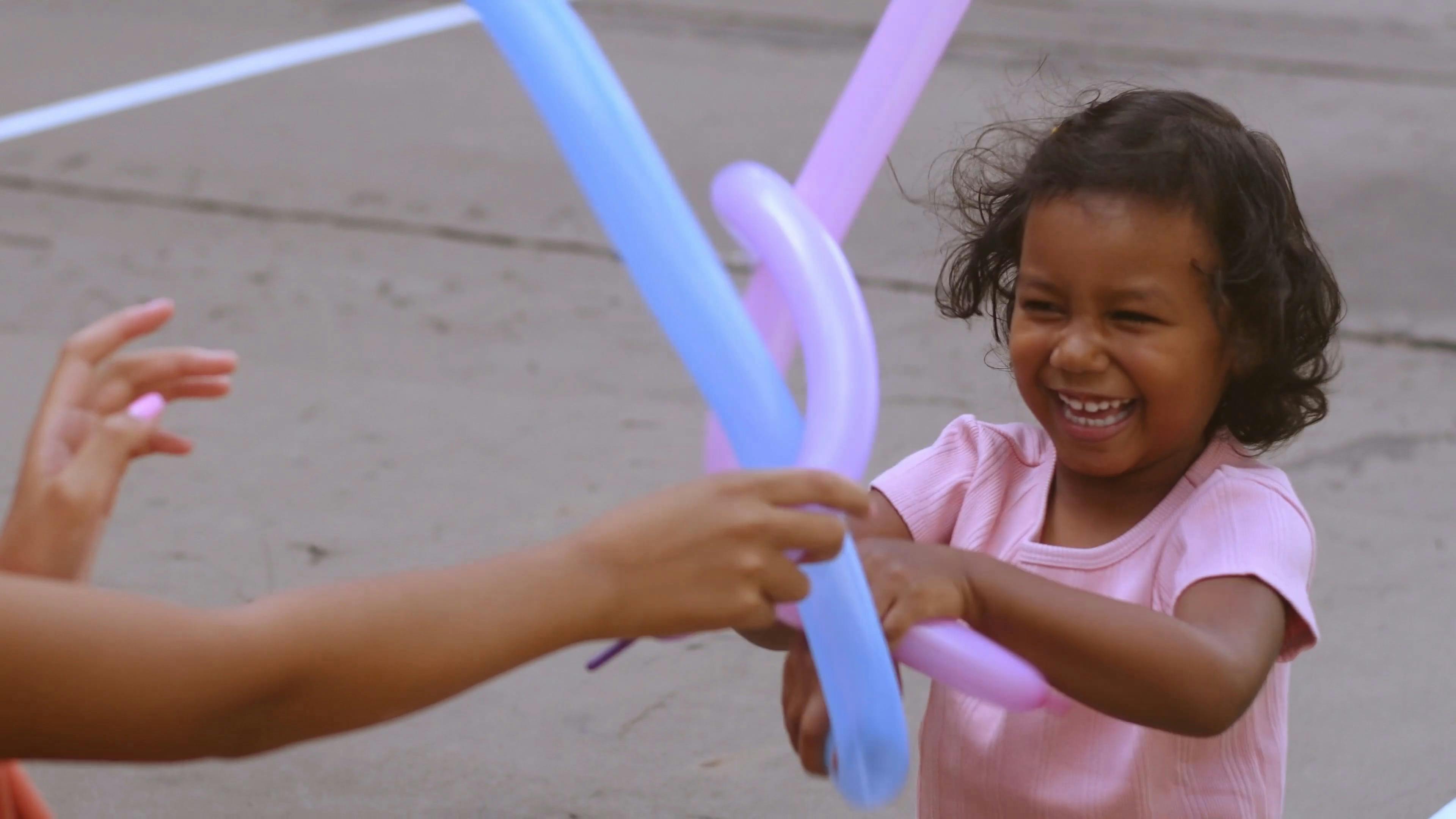 Girl Play Fighting with Long Balloons · Free Stock Video