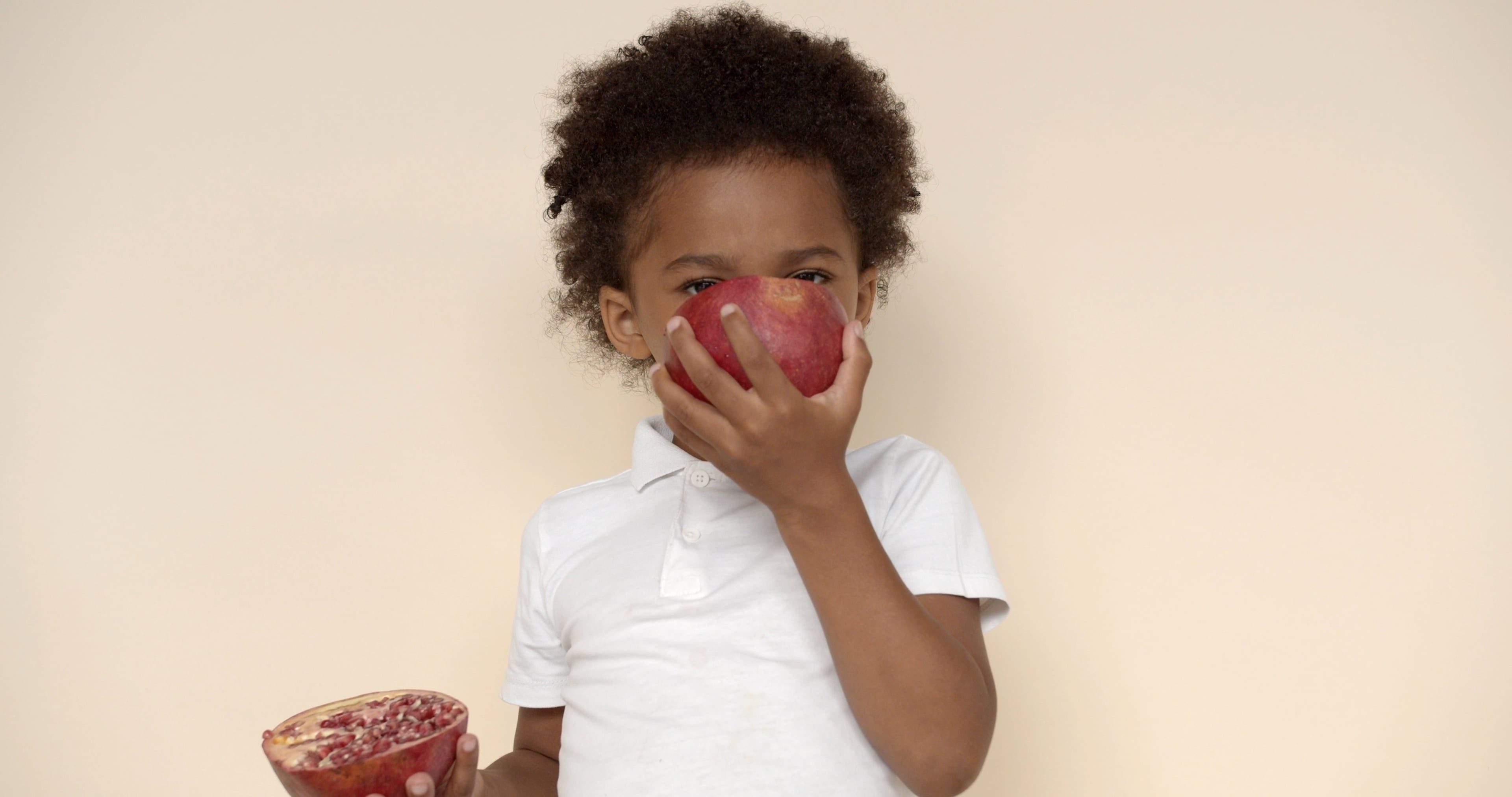 A Child in White Polo Shirt Eating a Fruit Free Stock Video Footage ...