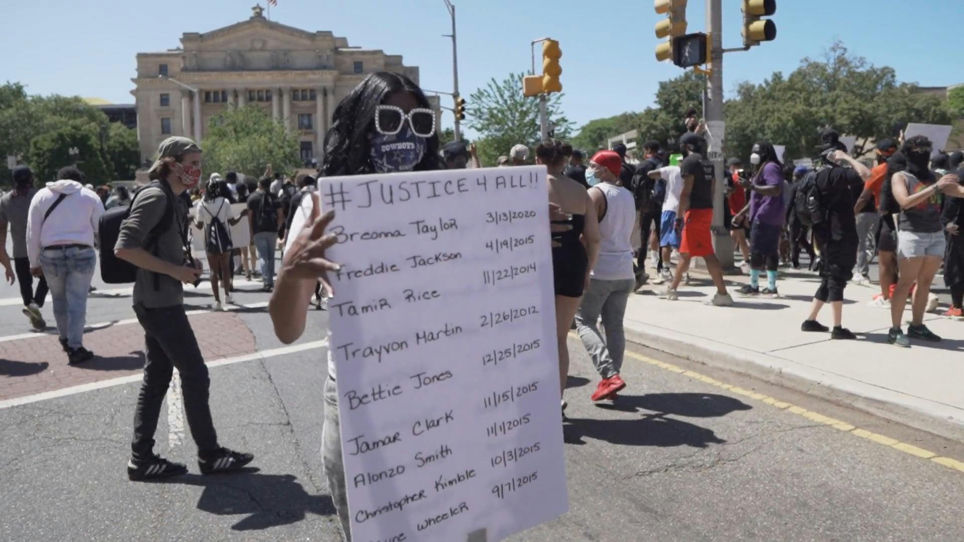 A Woman Holding a Placard in the Middle of a Rallying Crowd · Free ...