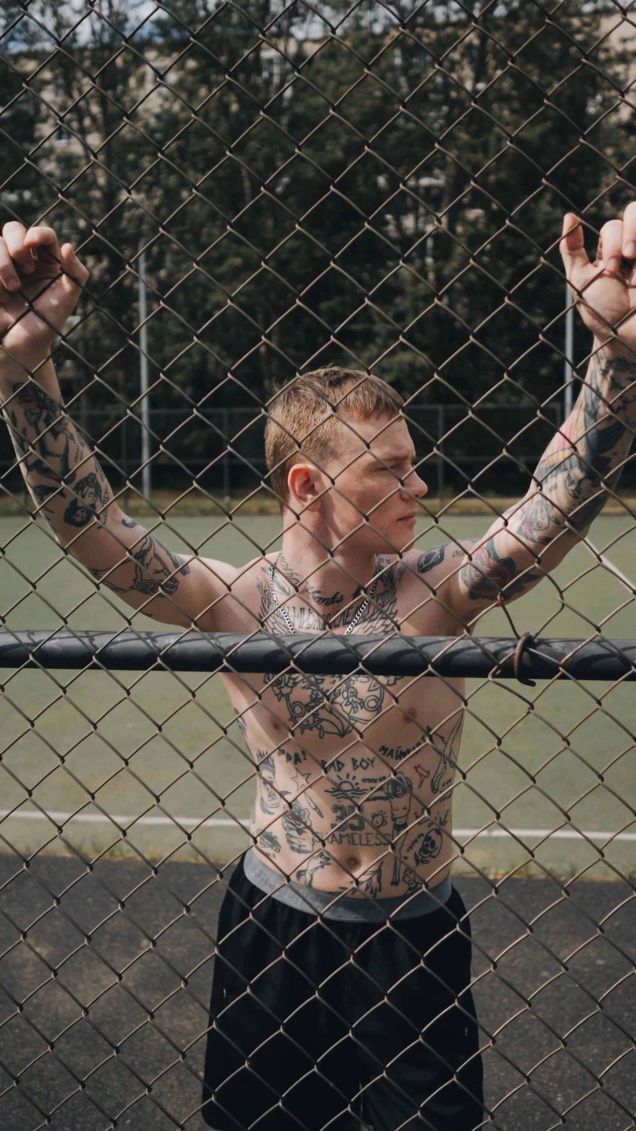 A Shirtless Man Behind a Cyclone Wired Fence Free Stock Video Footage ...