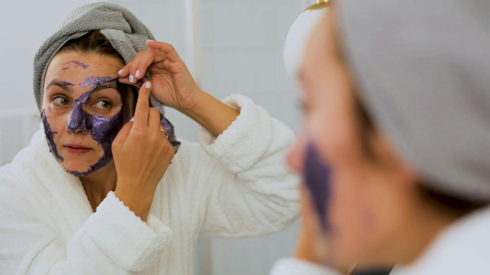 A Woman Removing Facial Mask In Front of a Mirror Free Stock Video ...
