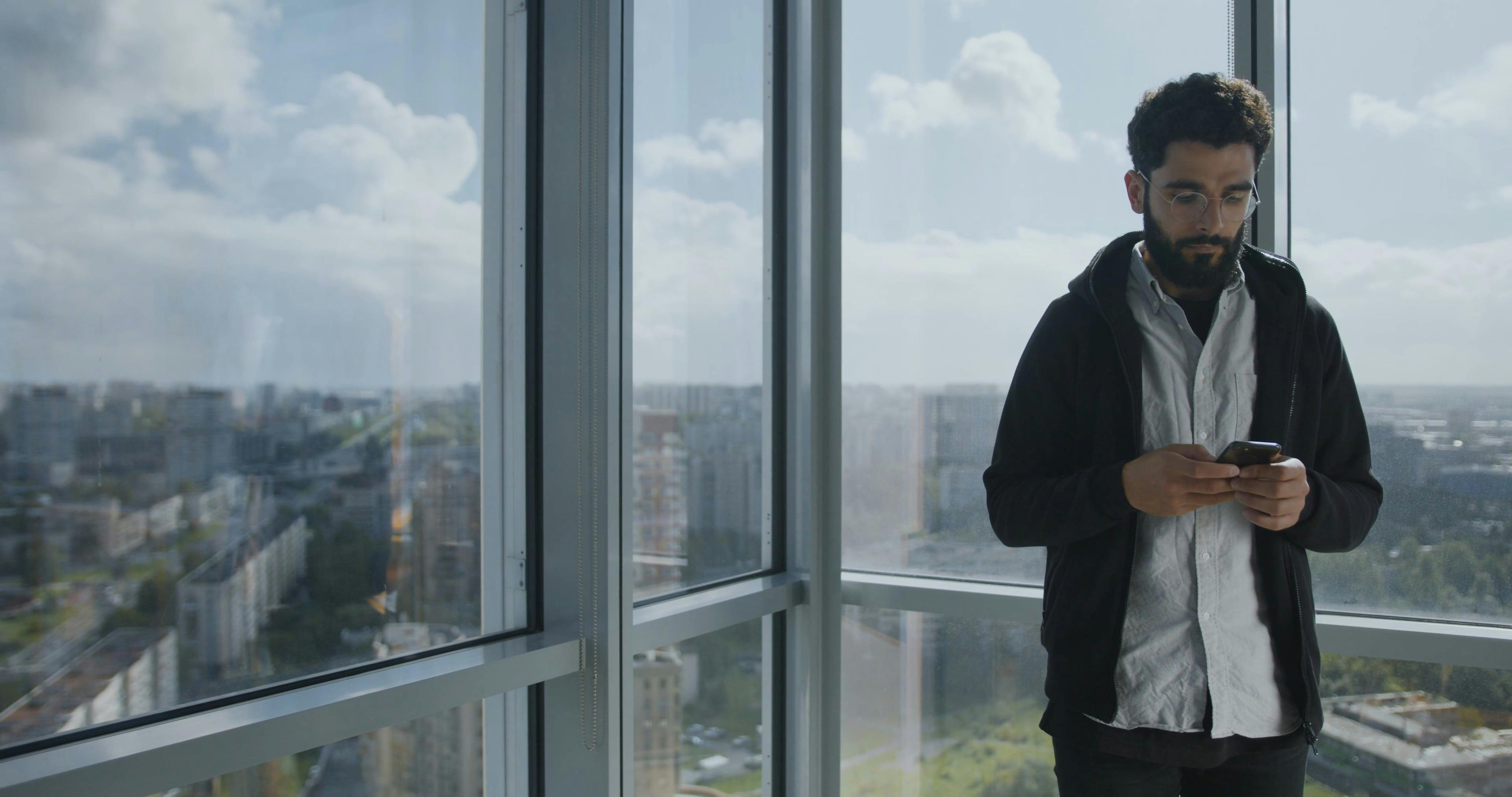 A Man Using Smartphone Beside the Window · Free Stock Video