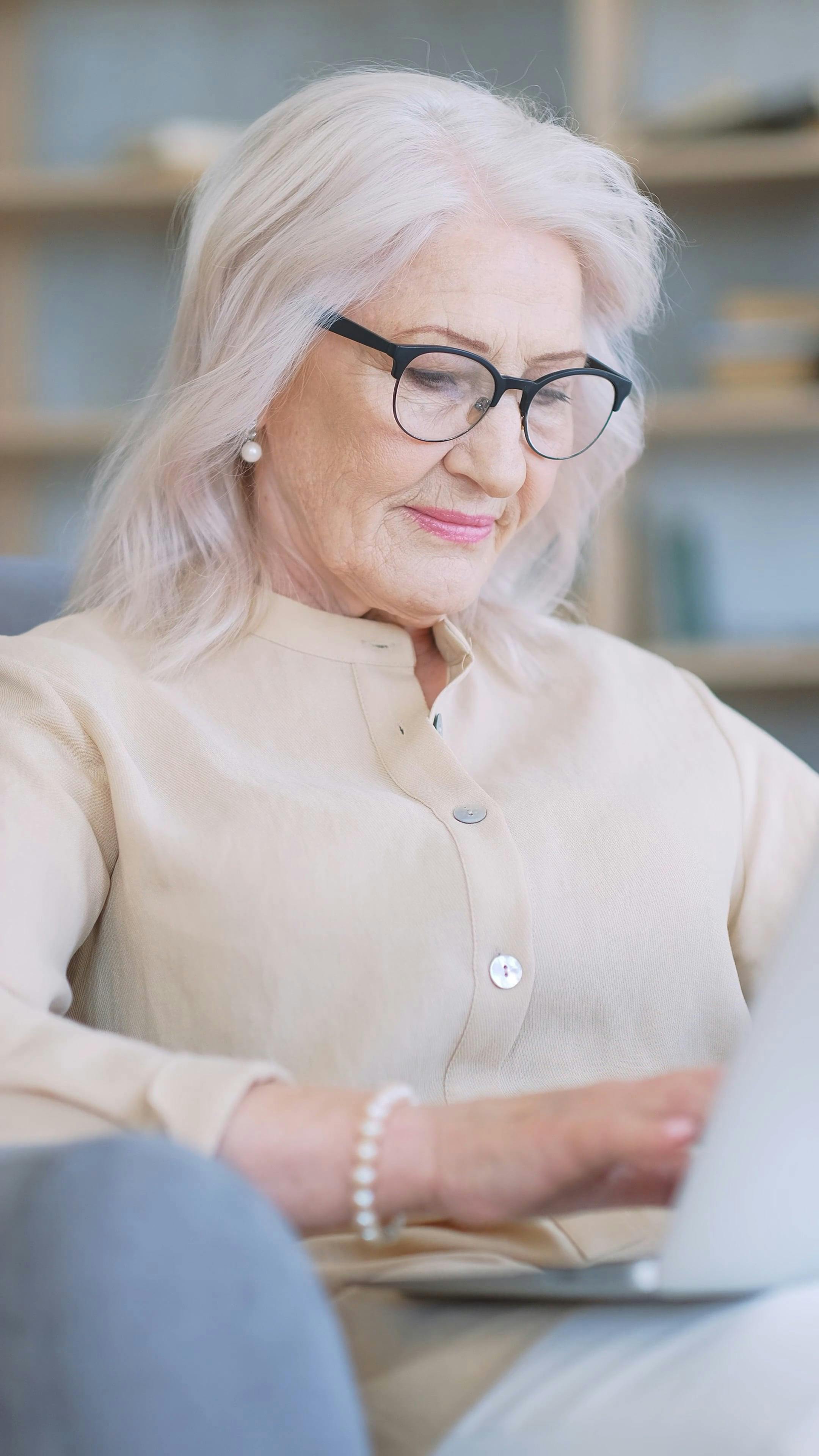 A Woman Wearing Eyeglasses While Using a Laptop · Free Stock Video