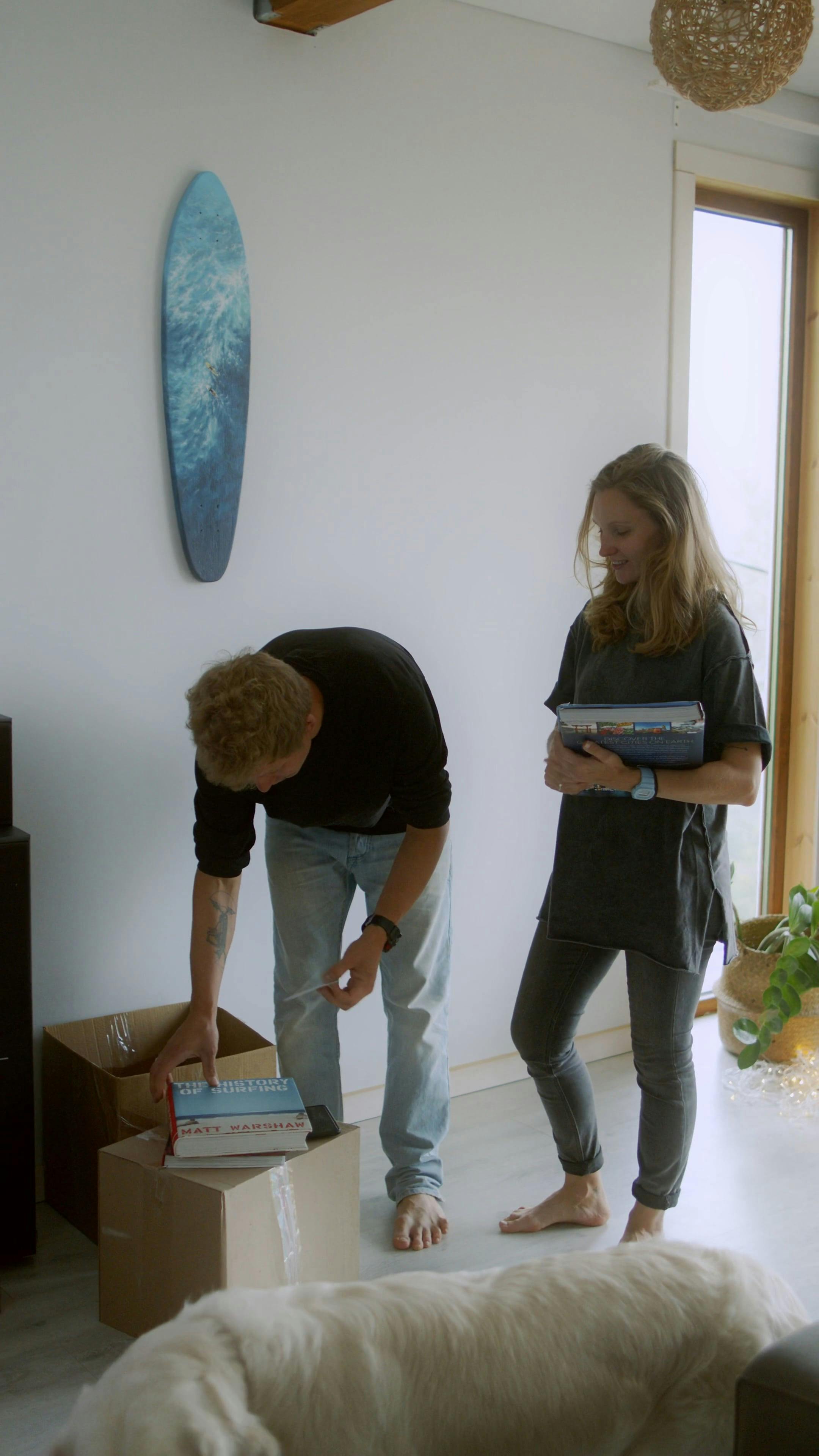 Couple Unpacking Books From Cardboard Boxes · Free Stock Video