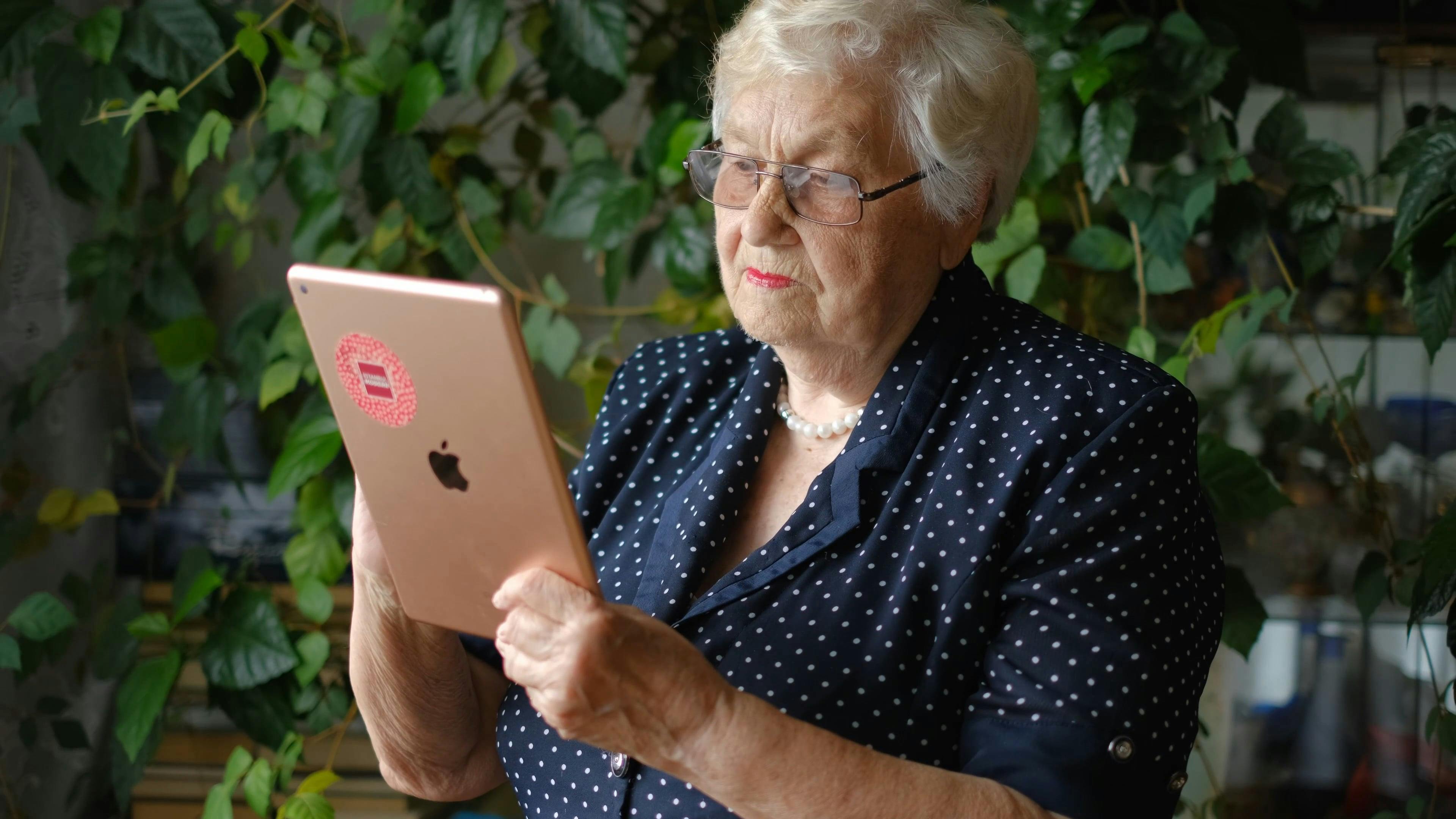 An Elderly Woman Using An Electronic Tablet Free Stock Video Footage ...
