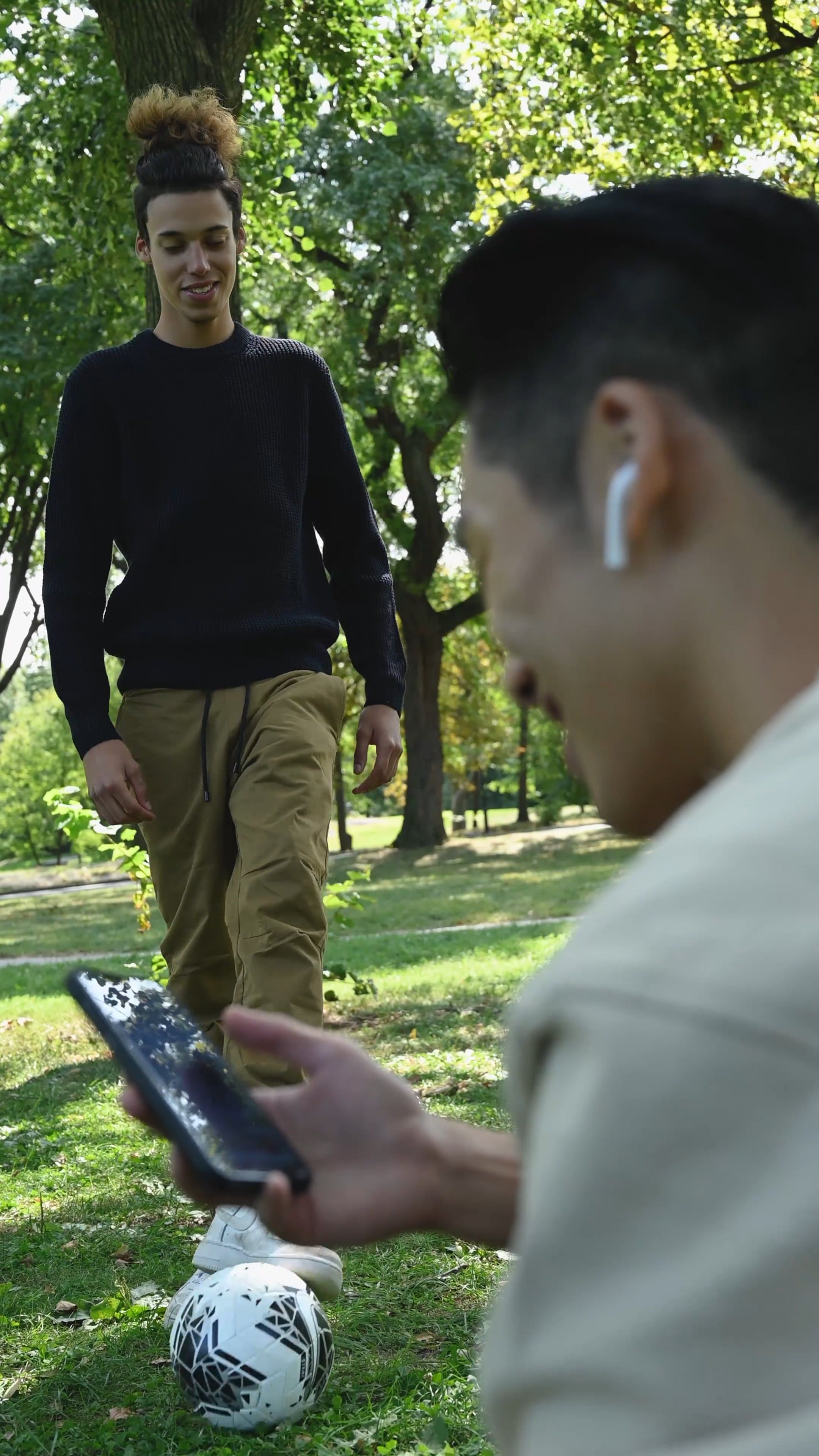 Guy Talking on Mobile Phone and His Friend Playing with Football · Free ...